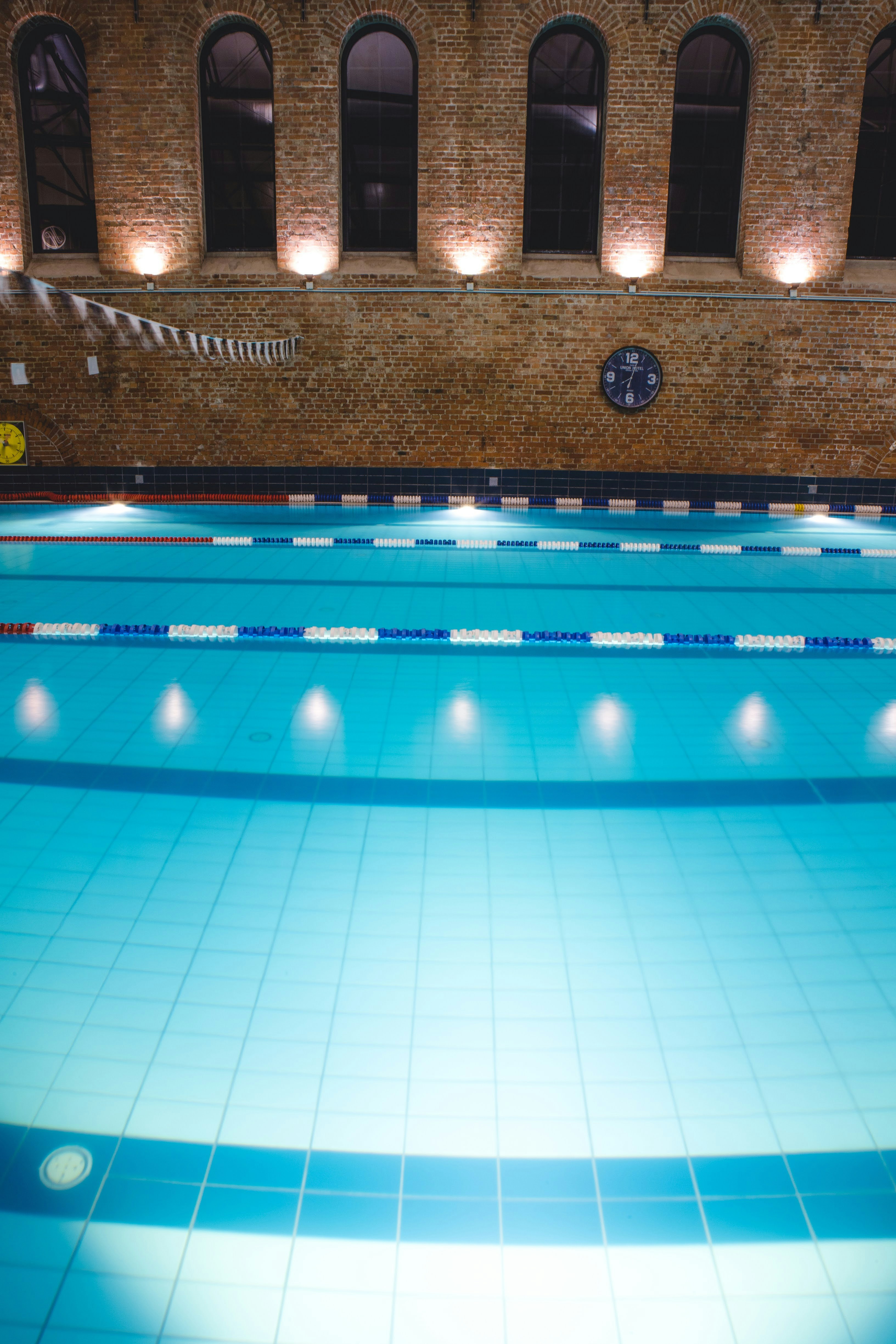 A swimming pool in a large brick building photo – Free Pool Image on ...