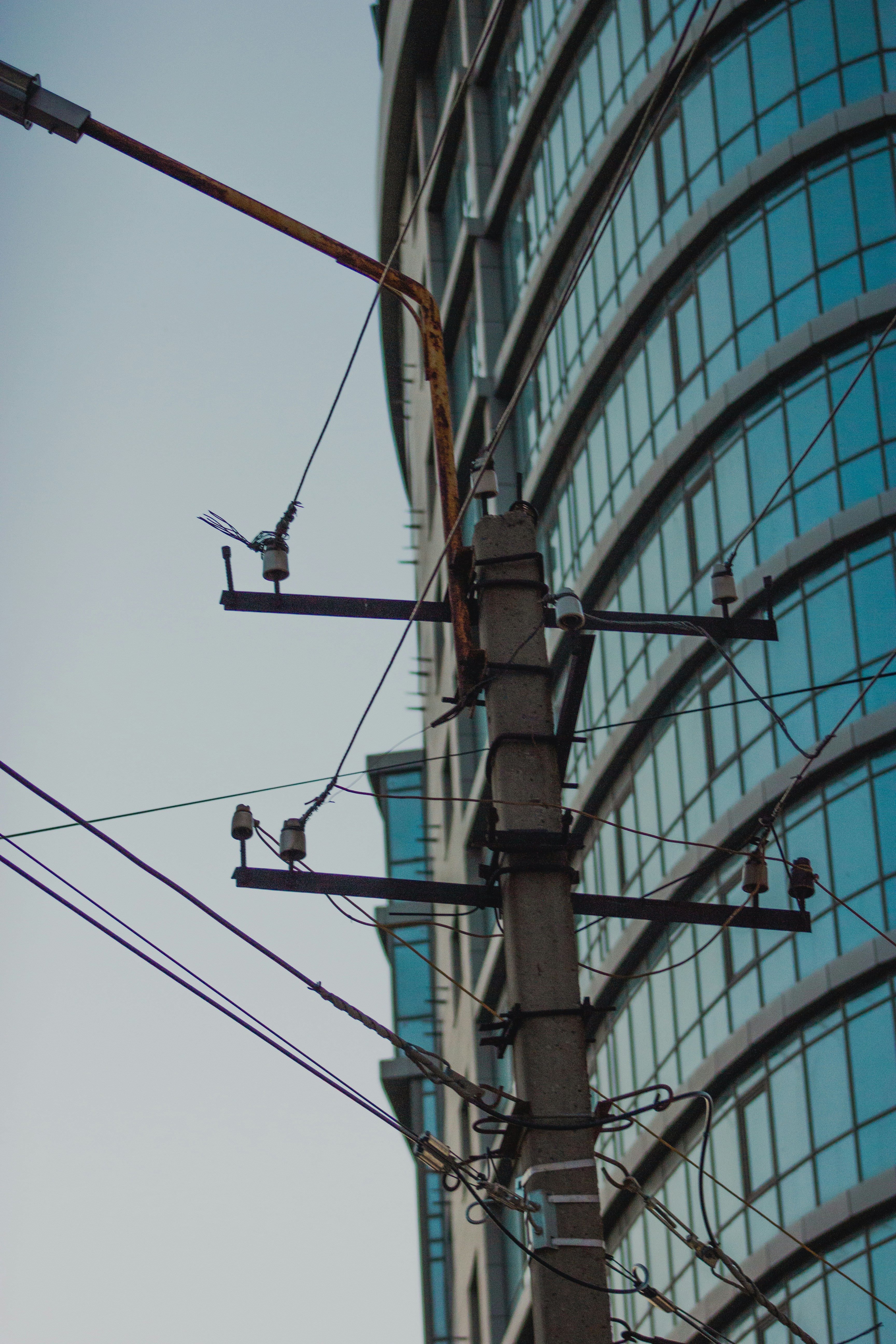 Urban Tension: The Weathered Utility Core Rising by Glass Facades