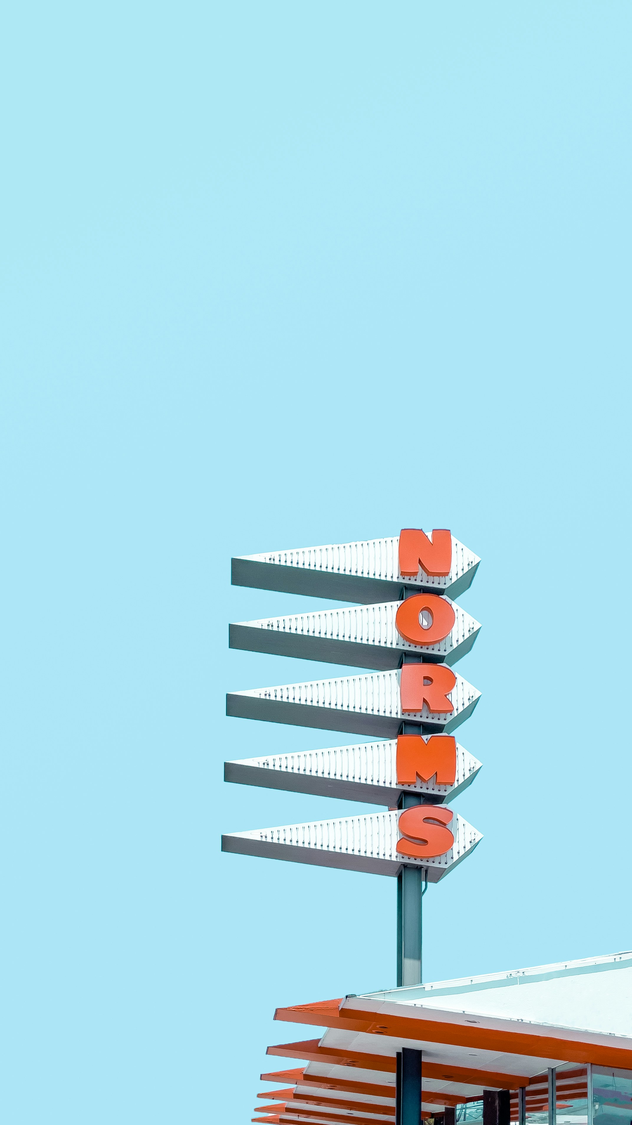 Norms Diner Sign: Vertical Arrow Stack in Orange Against a Powder-Blue Sky