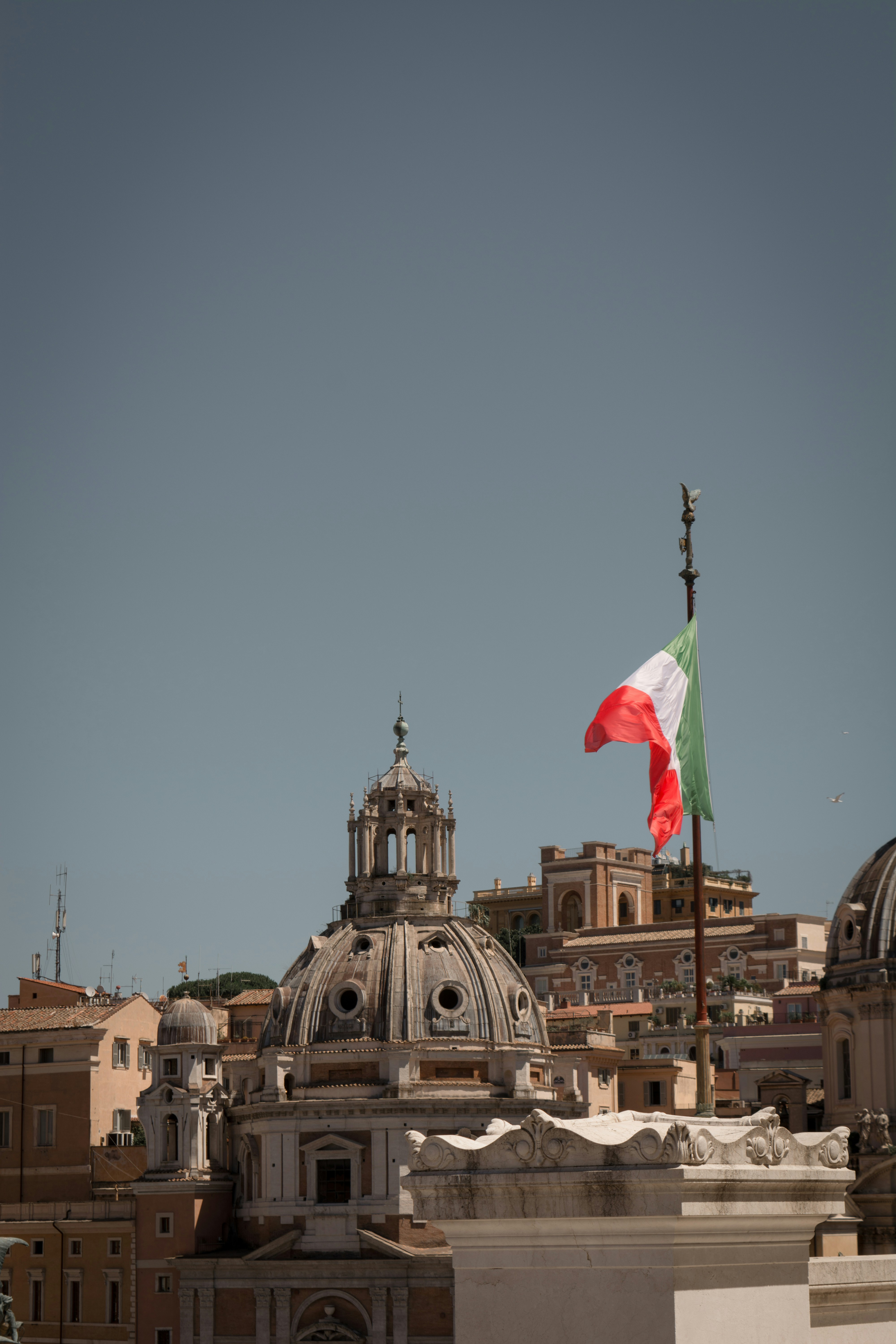 Flag Above Rome's Domes: Rooftop Panorama Under a Clear Sky