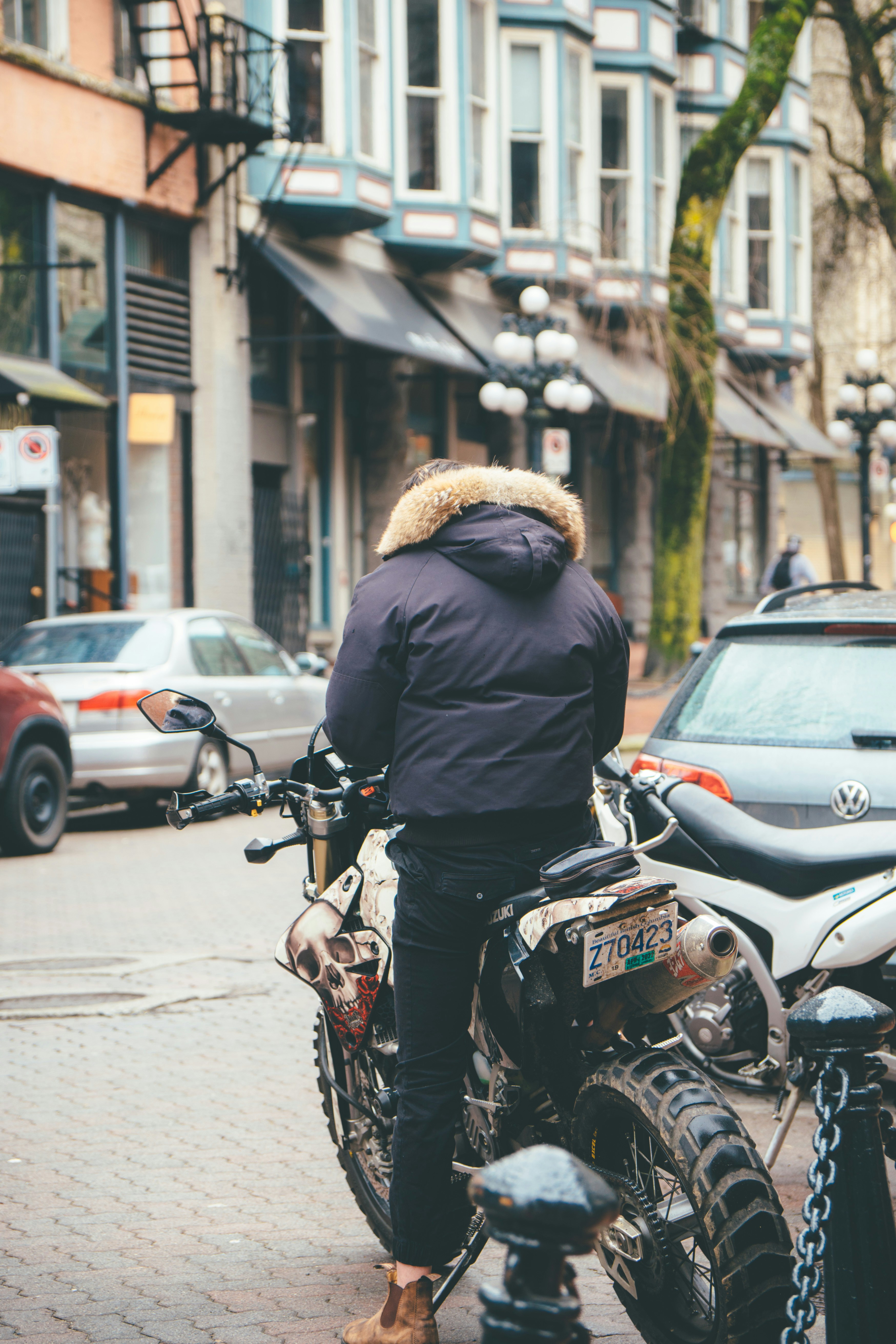 Midtown Rider by the Quiet Street: A Fur-Hooded Figure and a Bike in Soft City Light