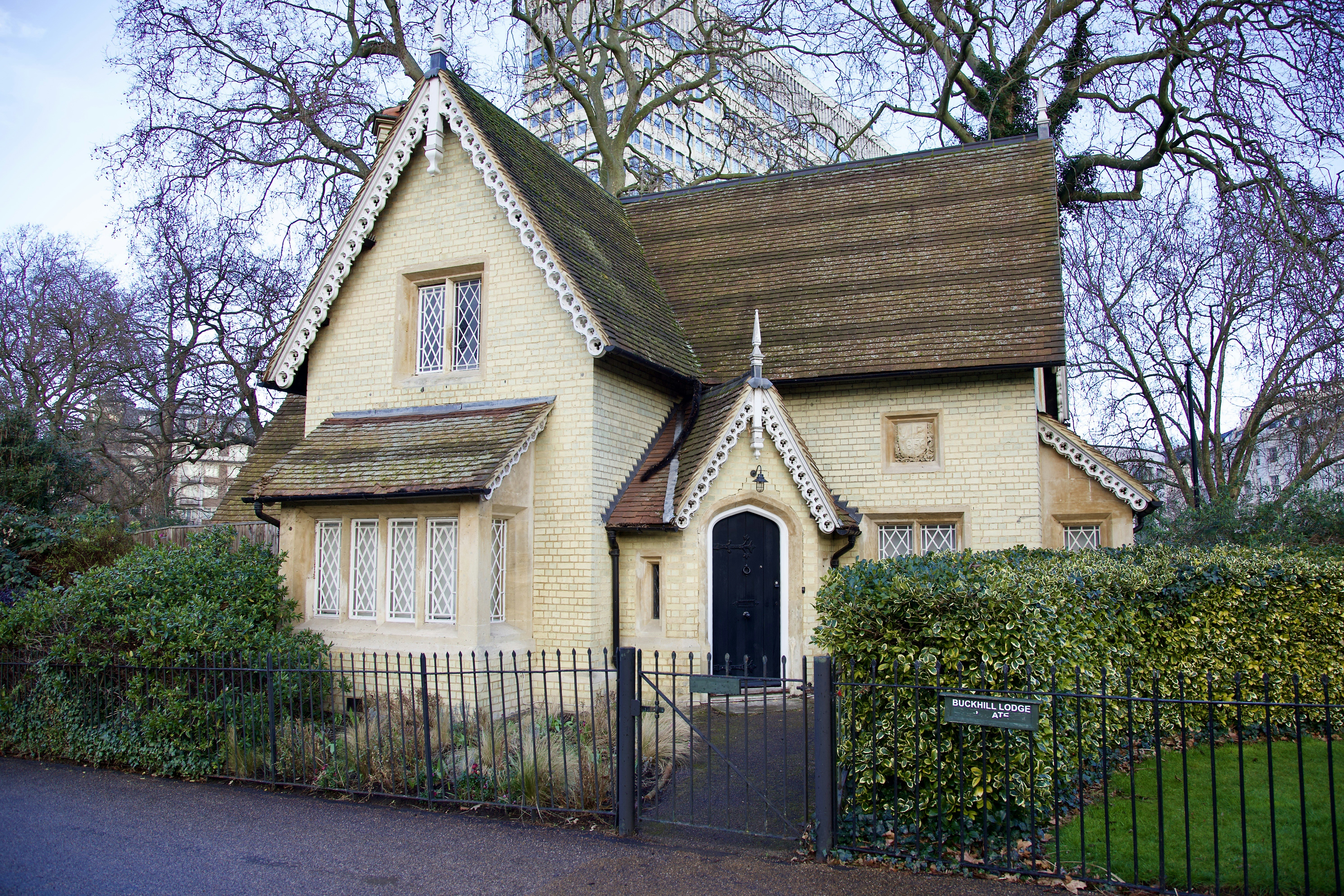Thatched English Cottage with a Dark Blue Door Framed by a Wrought-Iron Gate