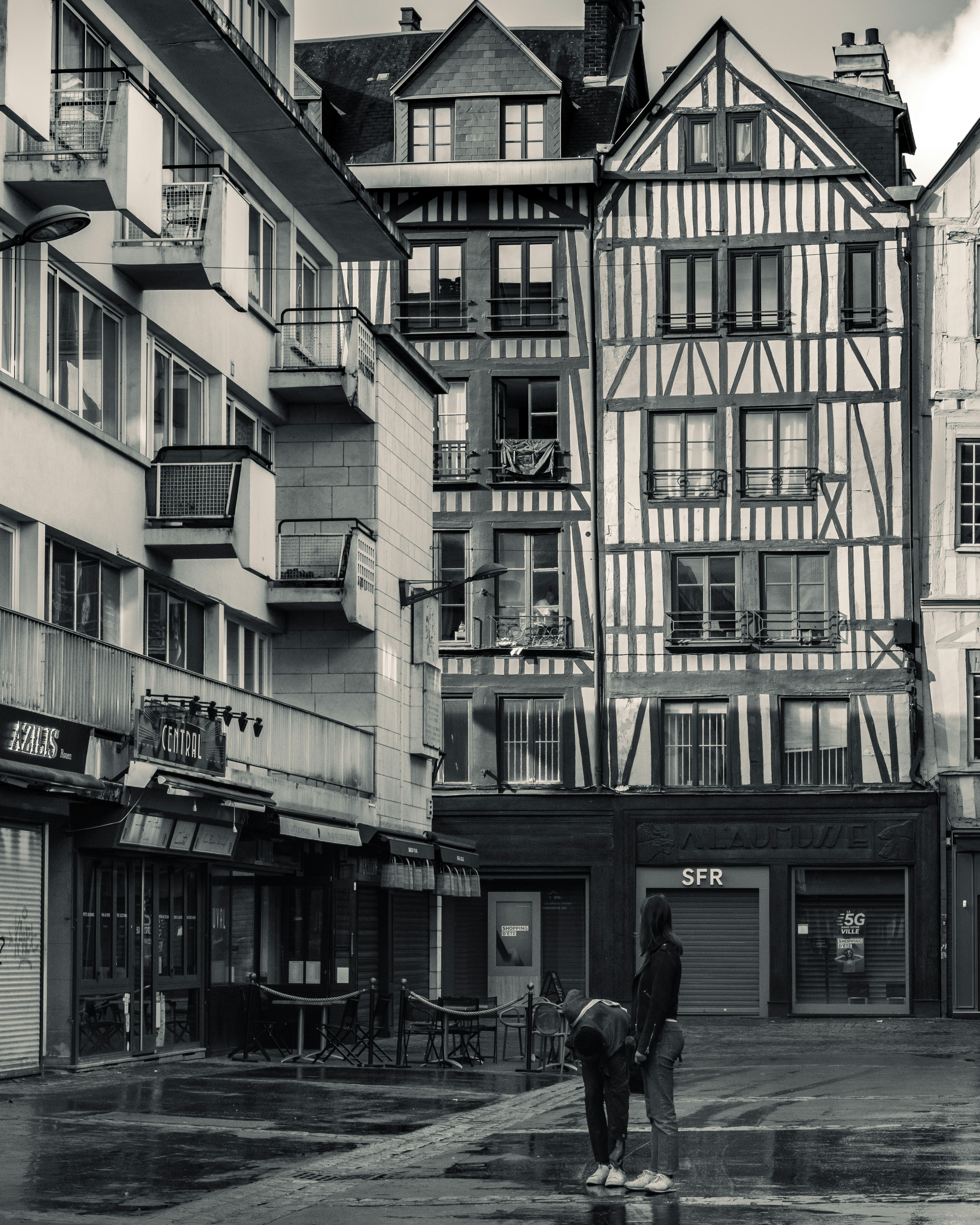 a couple of people standing in front of a row of buildings