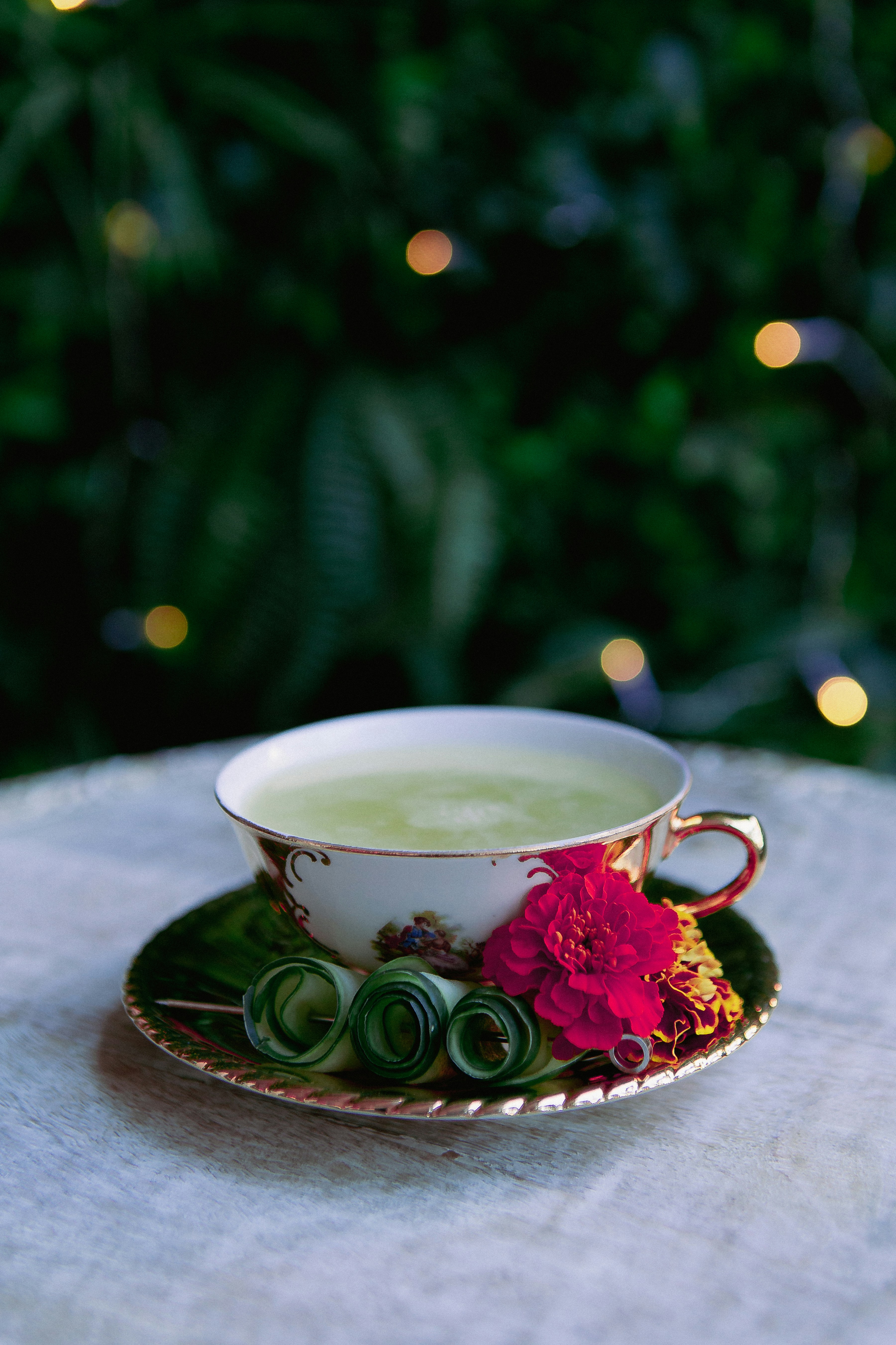 Creamy Green Tea in a Floral Teacup, Framed by Emerald Ribbons and a Pink Blossom