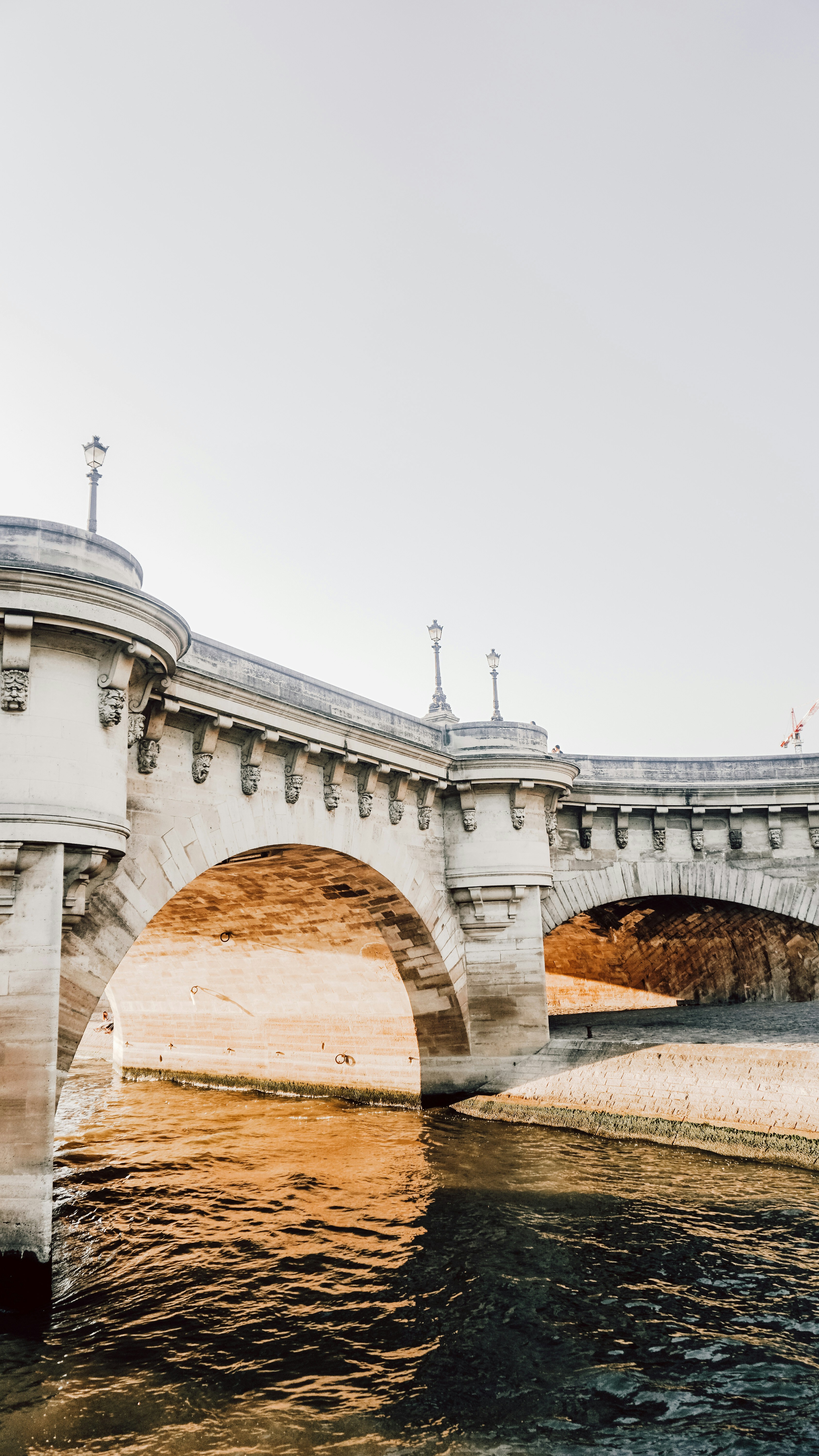 Sunlit Arches Over a Calm River: A Stone Bridge’s Quiet Rhythm
