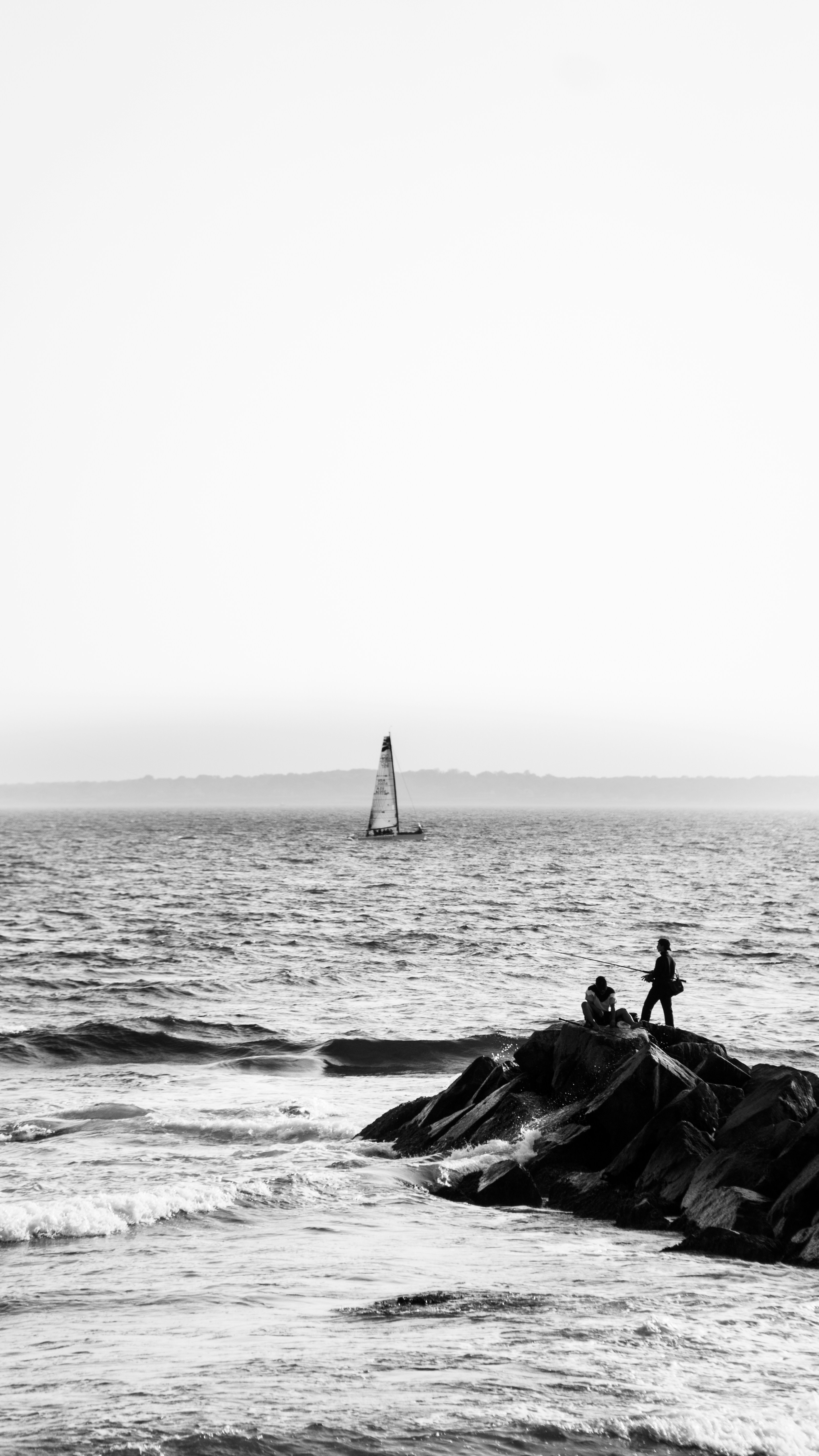 Lone Sail on a Quiet Horizon: Rockbound Figures at the Breakers