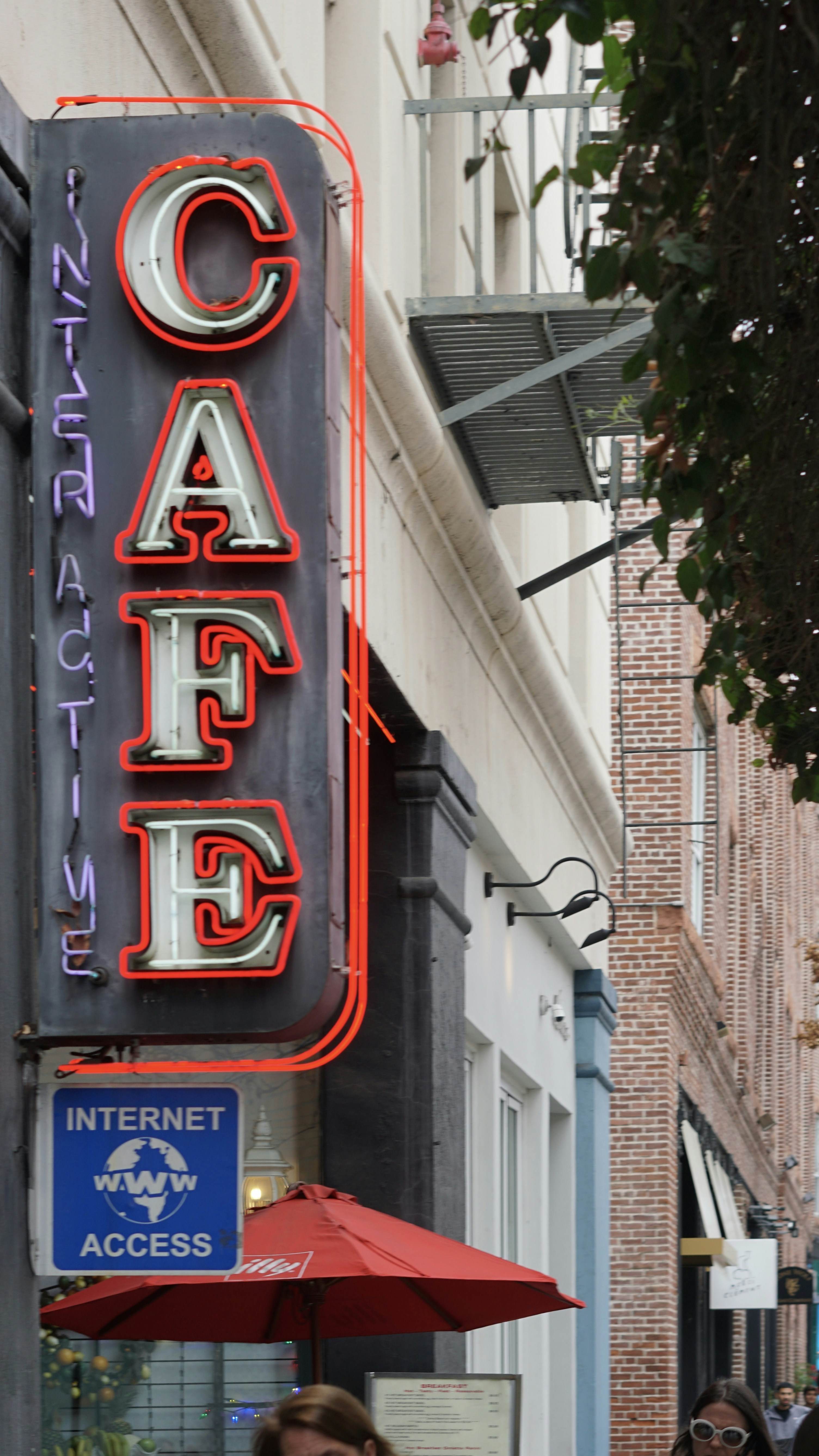 Crimson Neon Café Sign Casting a Neon Glow on a Brick Urban Alley