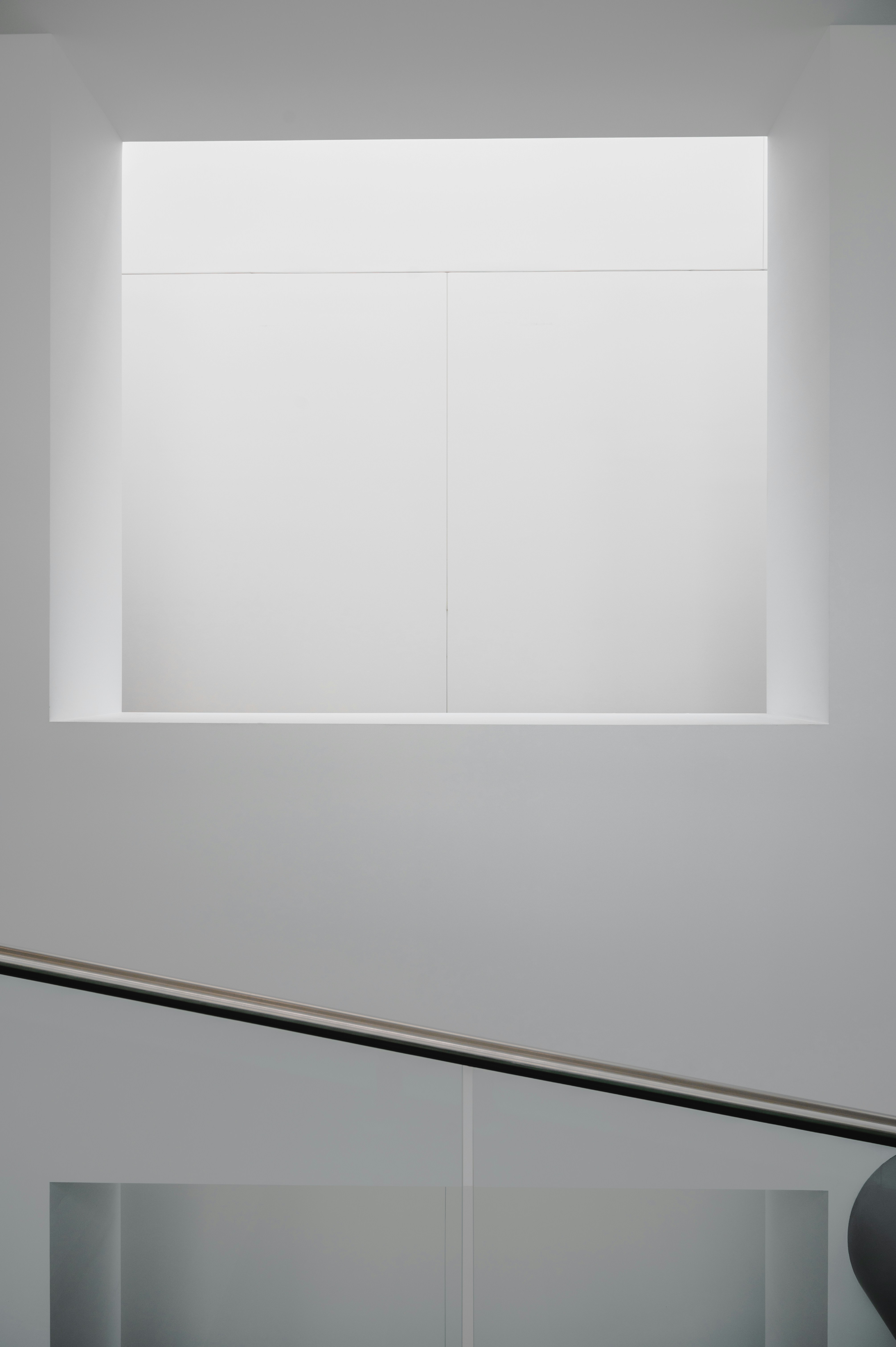 A softly lit window set in a minimalist wall, showcasing clean lines and a serene atmosphere.