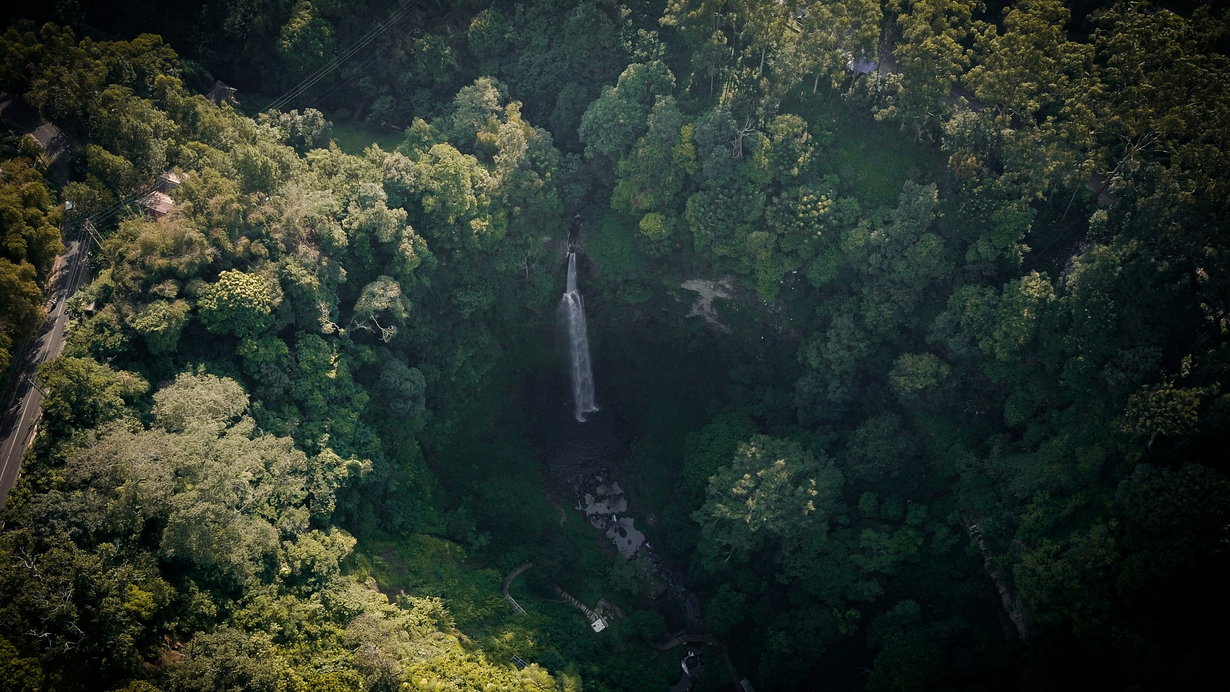 Waterfall nestled within a dense forest canopy in Cimahi, West Java.