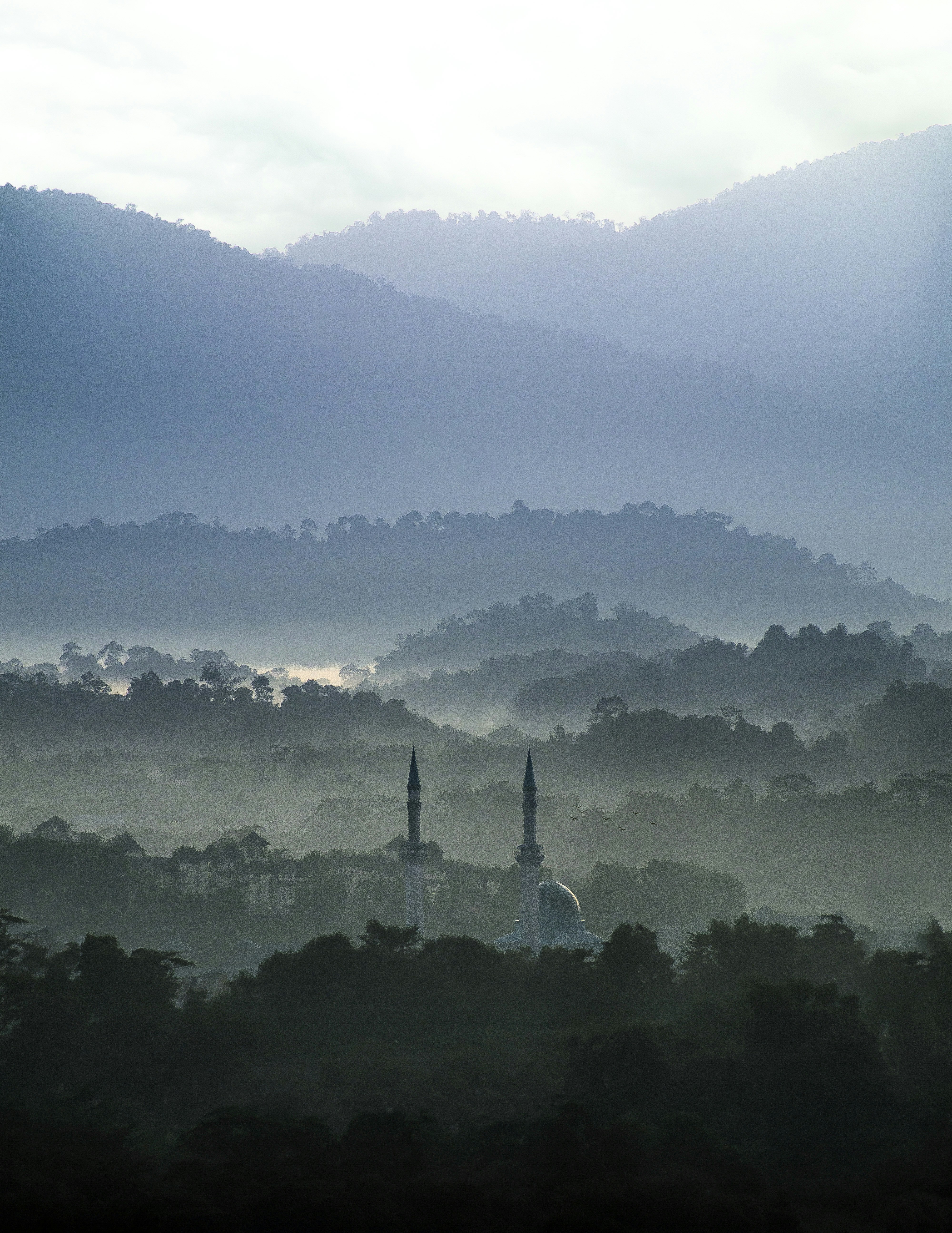 Dawn Veil Over Twin Minarets Amid Misty Ridge