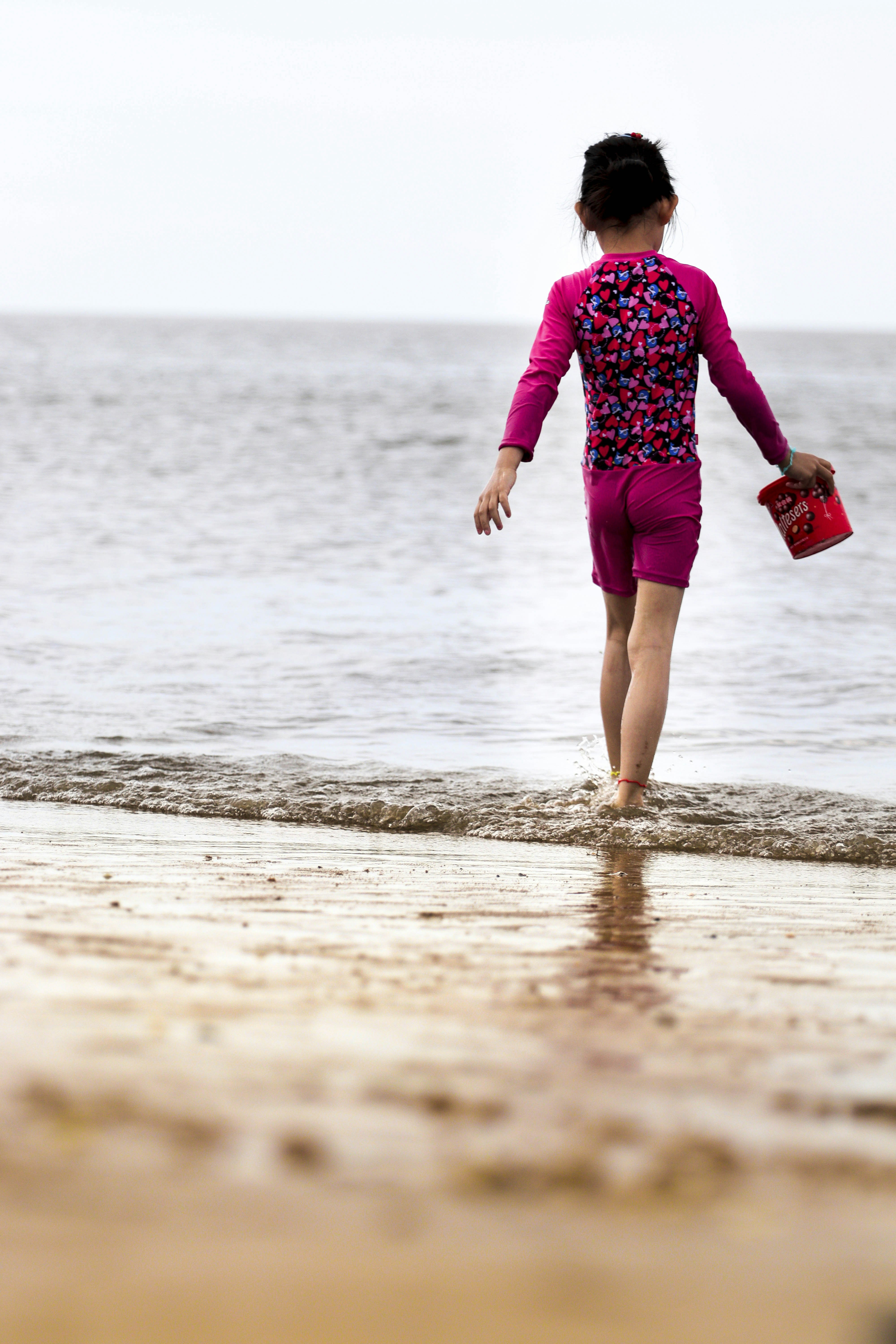 a girl walking on the beach