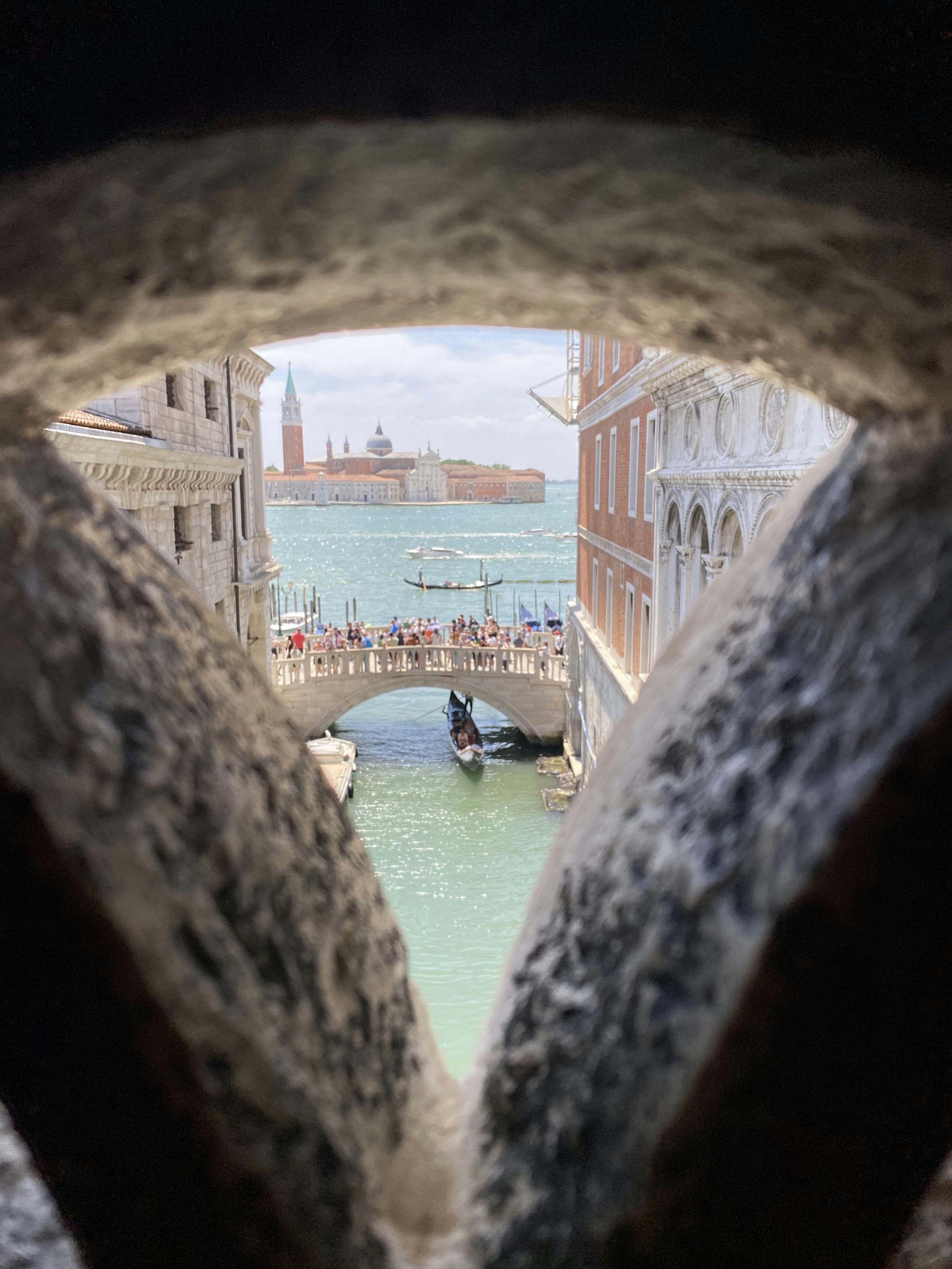 Venice through a Stone Aperture: Boat, Bridge, and Turquoise Canal