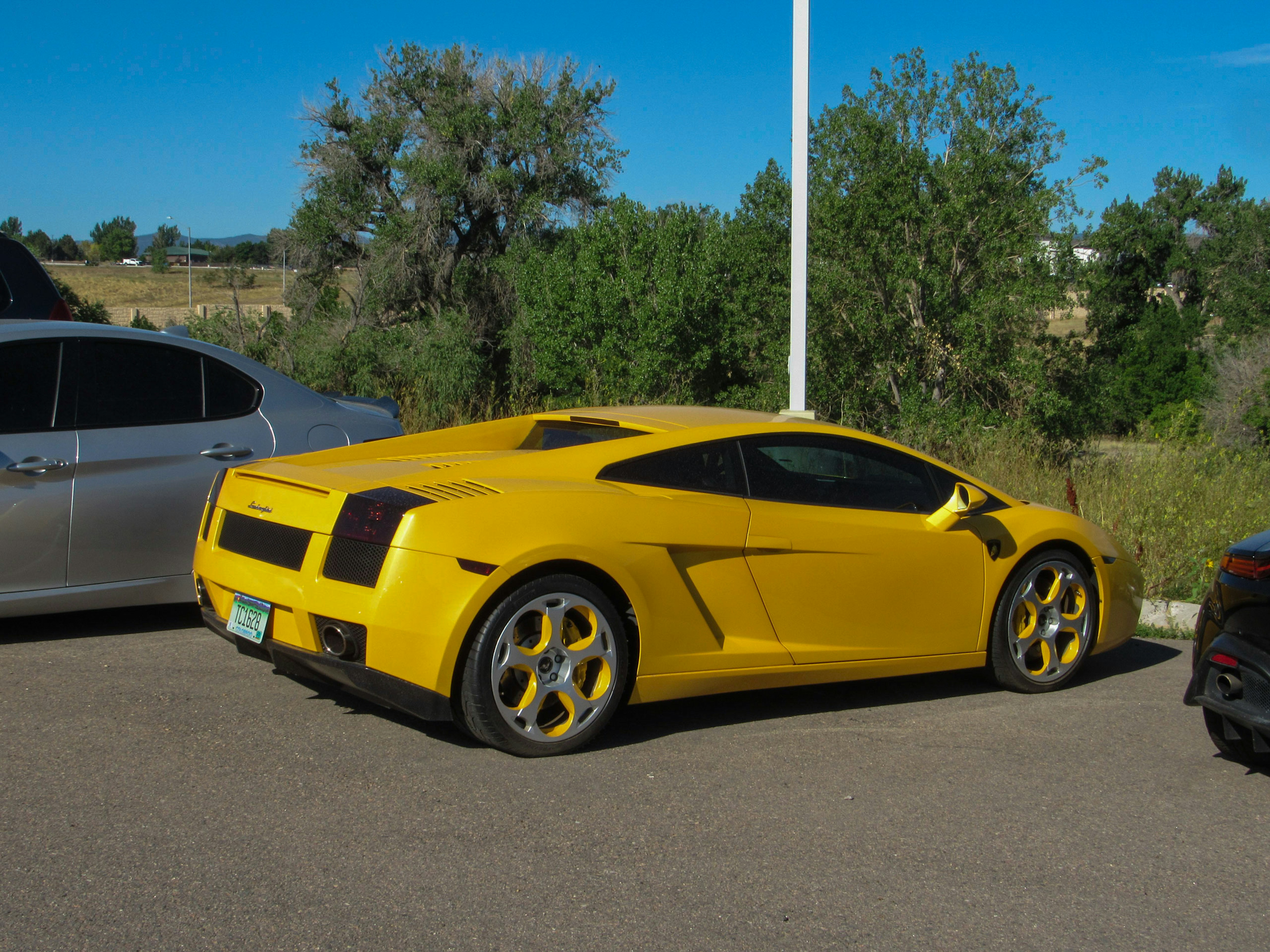 Foto Un coche deportivo amarillo estacionado en una carretera con otros ...
