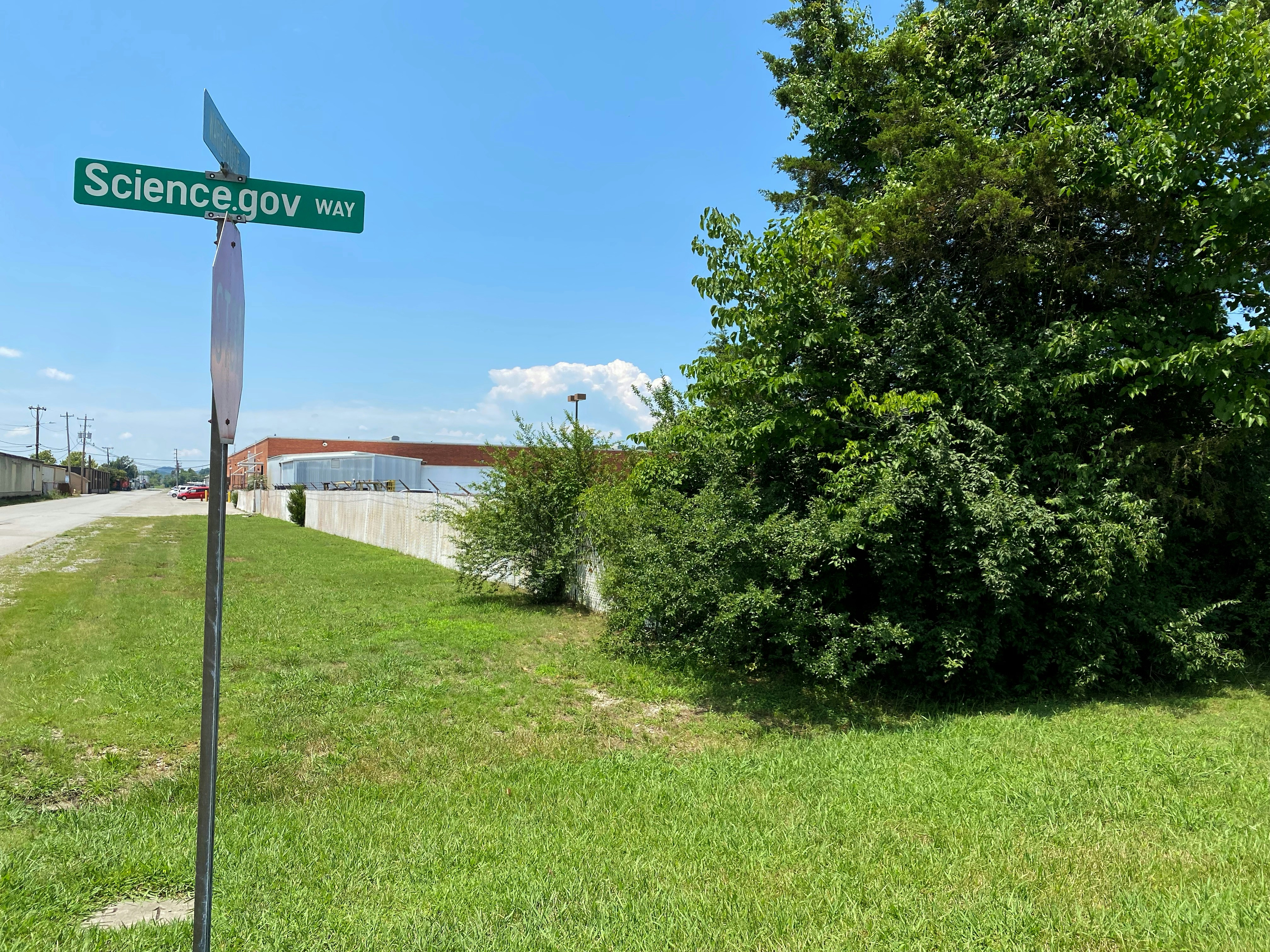 Street sign for Science Blvd near lush greenery and a clear blue sky.