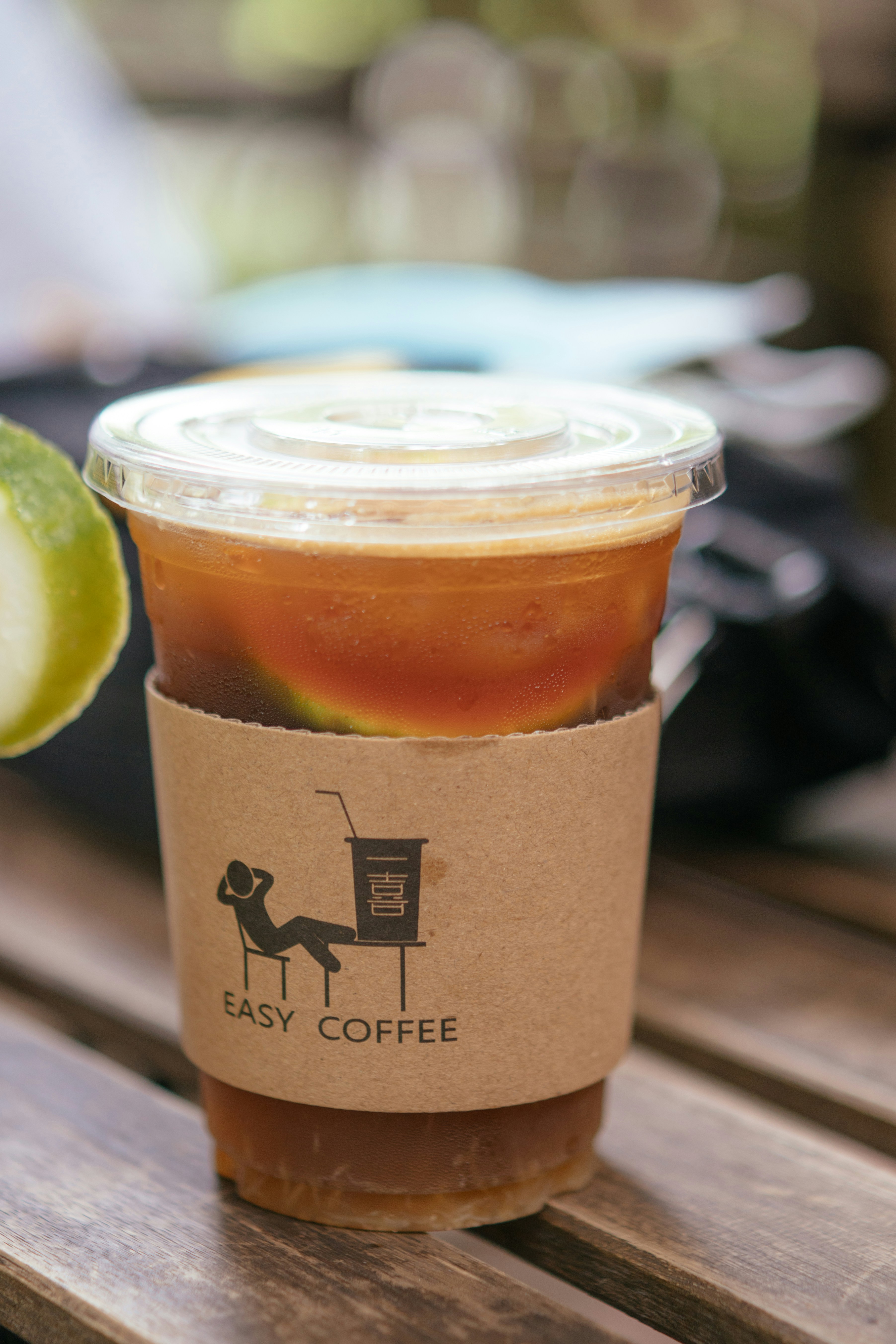 Sunlit Iced Coffee with Easy Coffee Sleeve on Weathered Wood