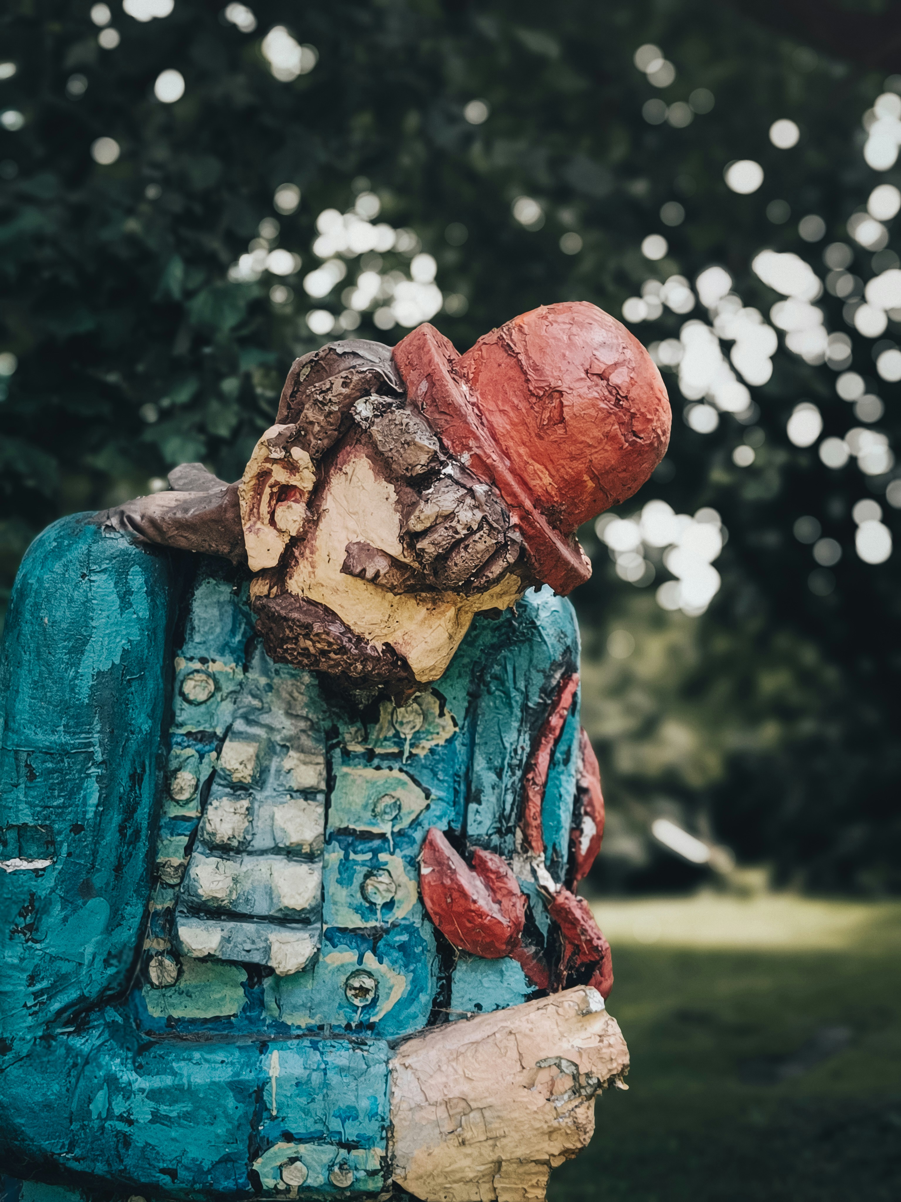Vibrantly painted wooden statue of a man in a blue coat and red hat, exuding a sense of nostalgia and artistry.