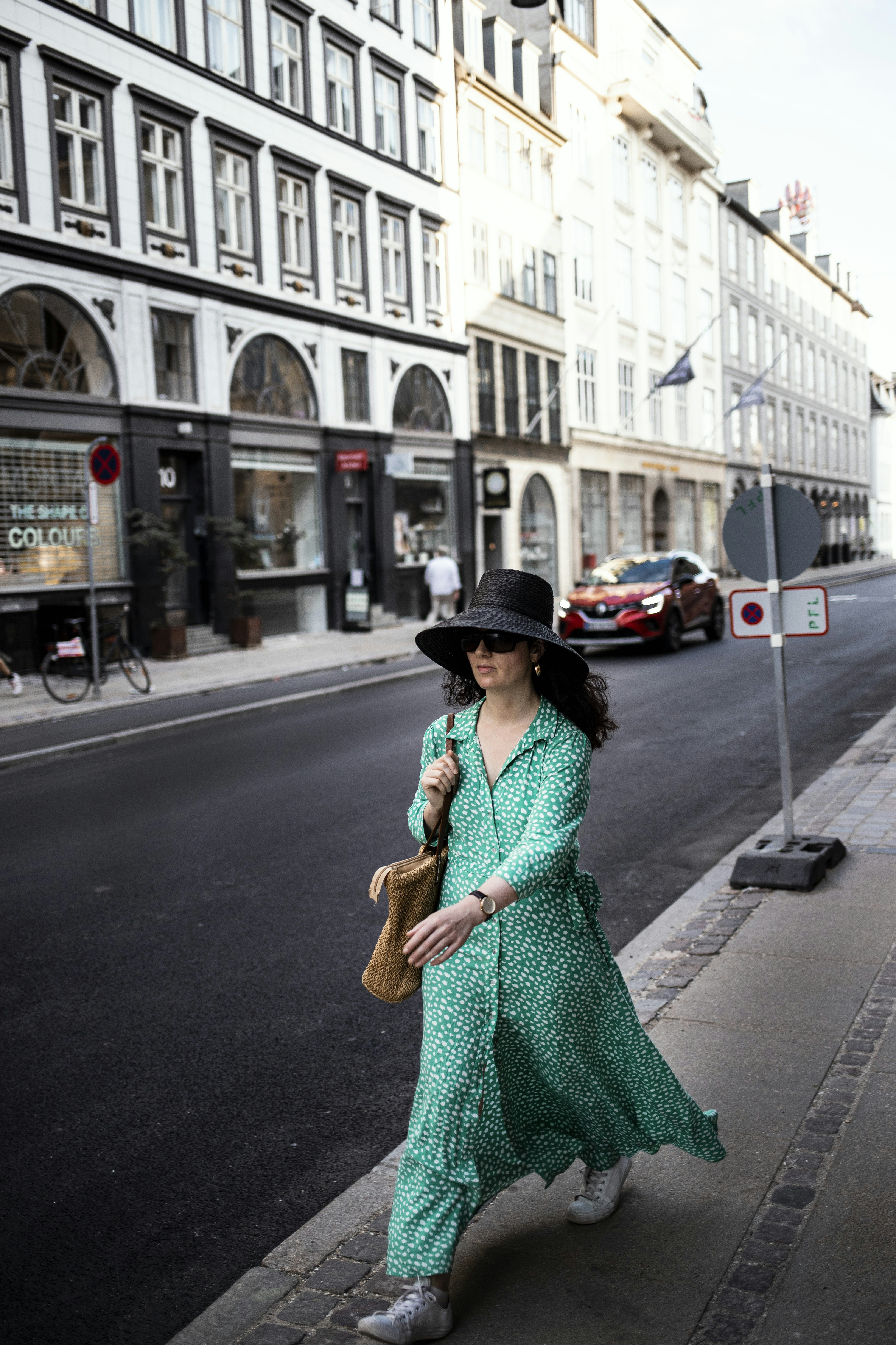 Green dress on the move: a stylish walk down a European street