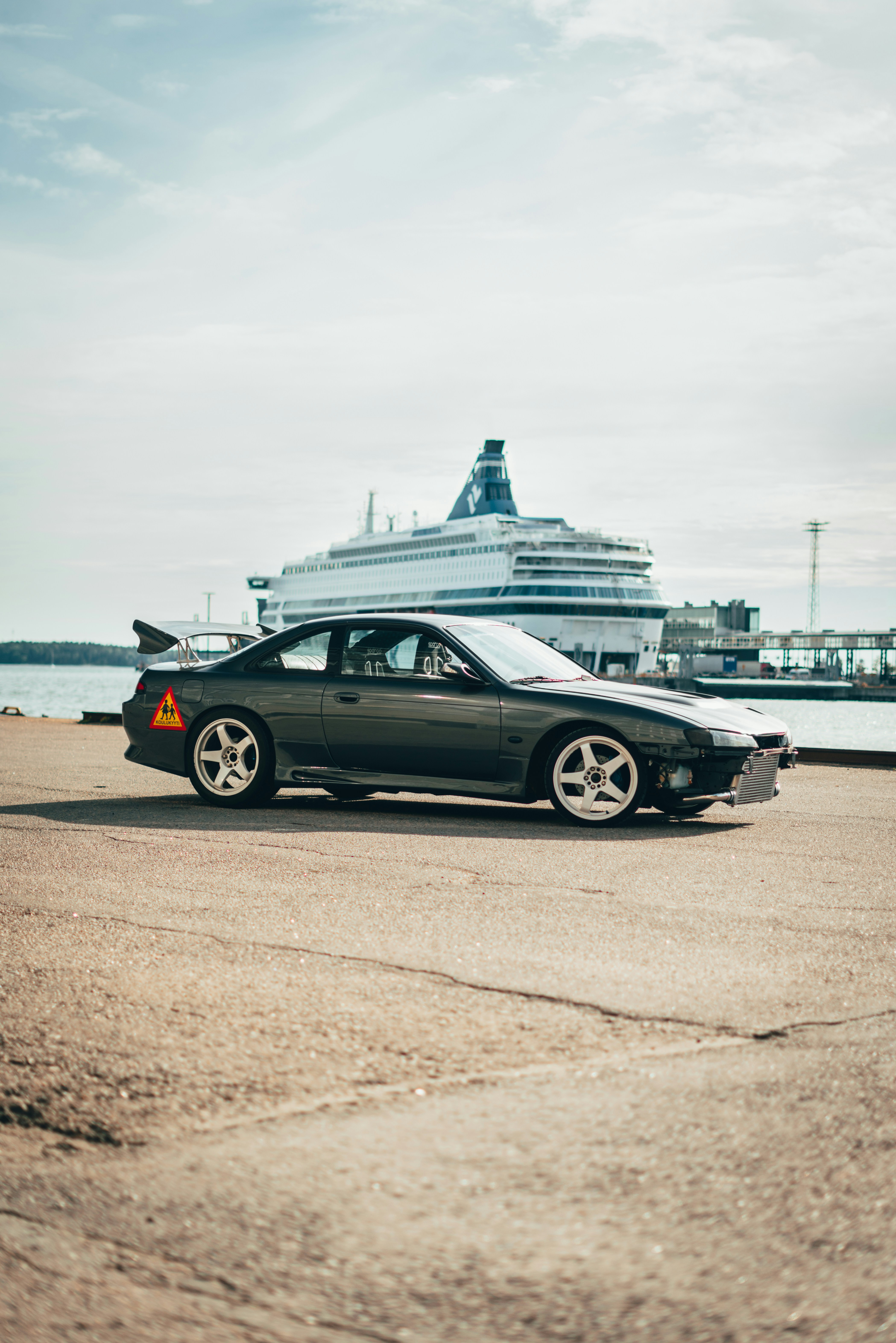 A car parked on a road near a large ship photo – Free S14 Image on Unsplash