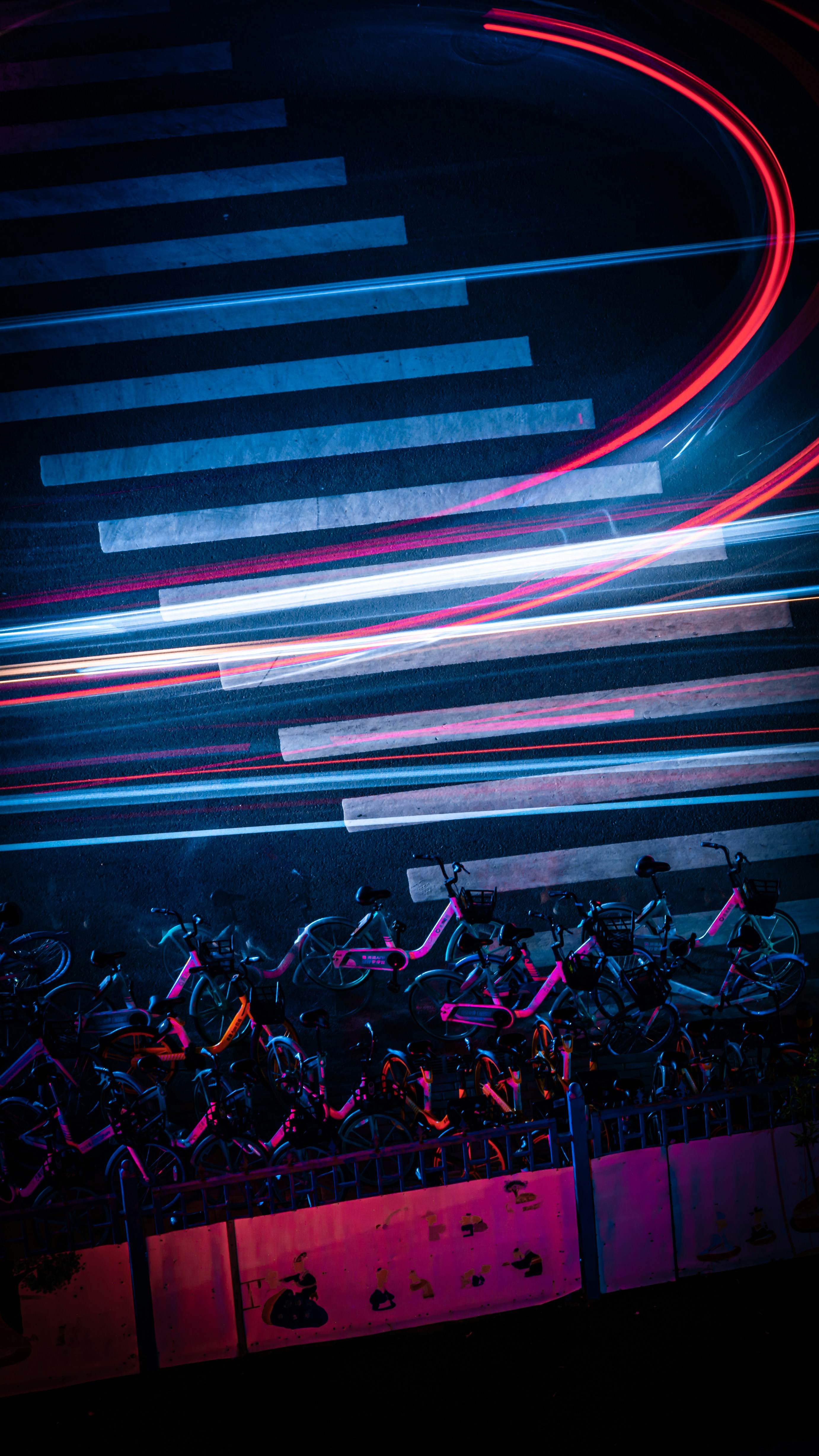Neon Arcs Over Pink Bikes: Night Crosswalk in Long Exposure