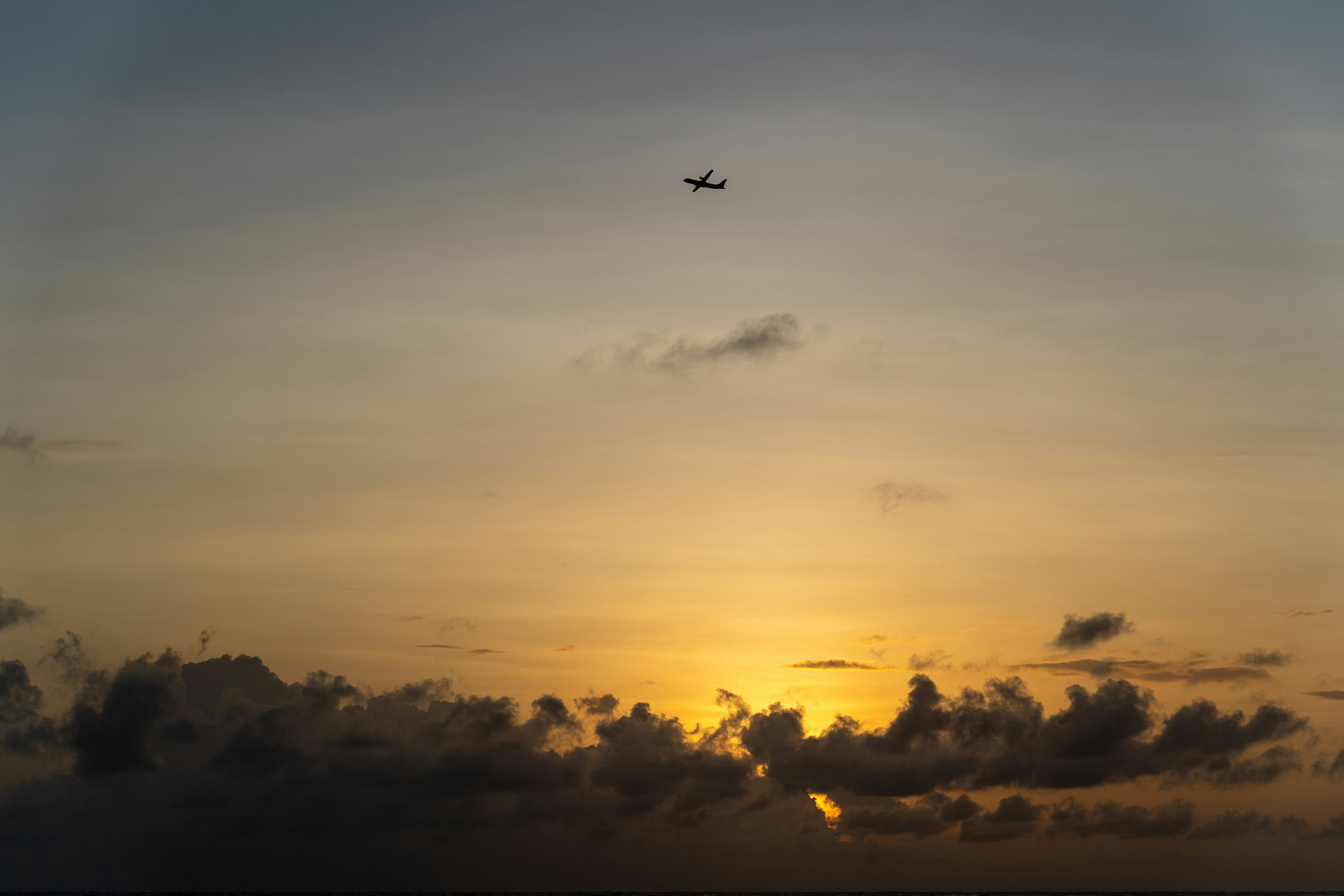 Lone Jet Silhouette Over a Golden Dusk Sky