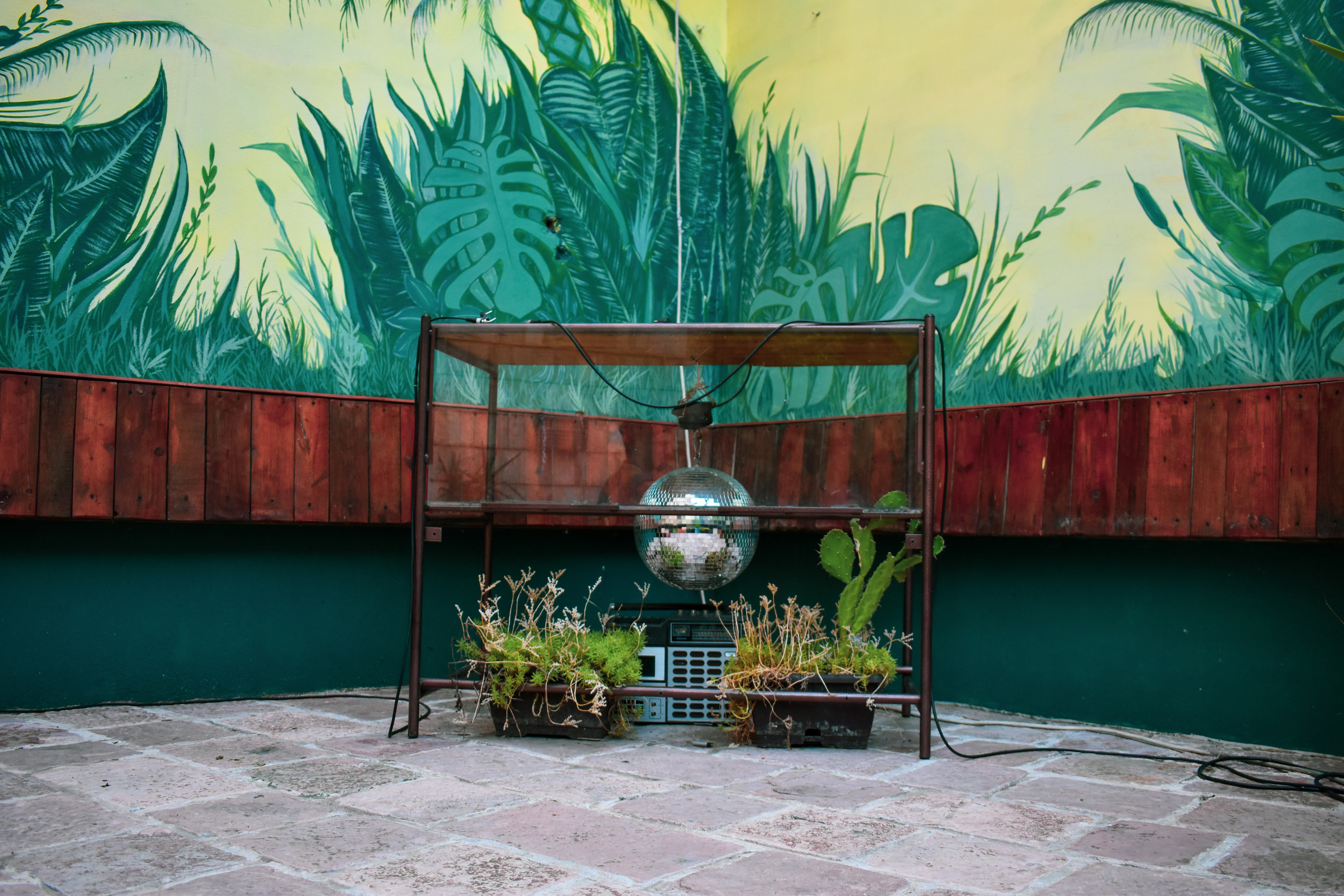 a metal structure with plants and a globe on it