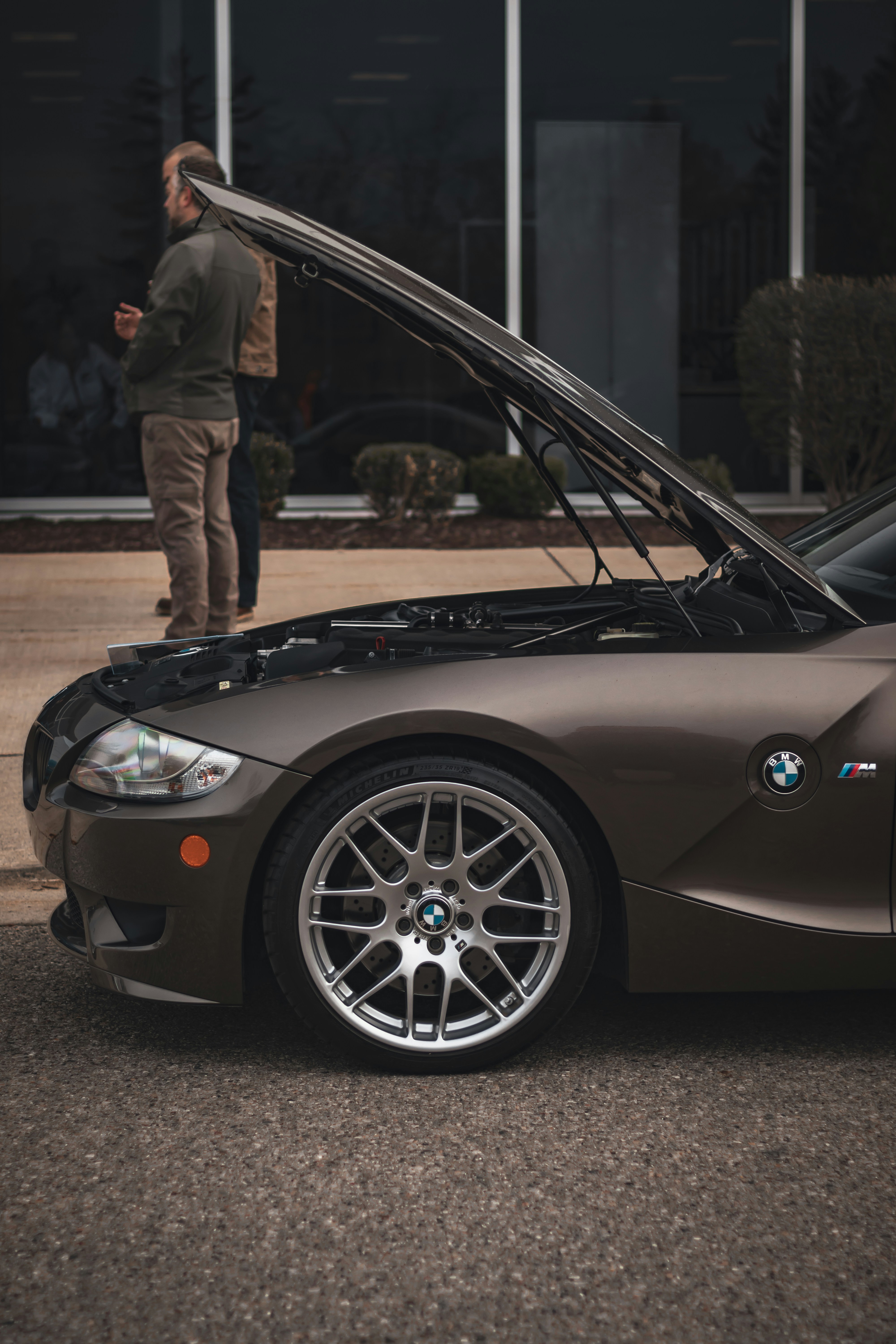 Underlit Prestige: The BMW sits in quiet foreground as the hood stands open