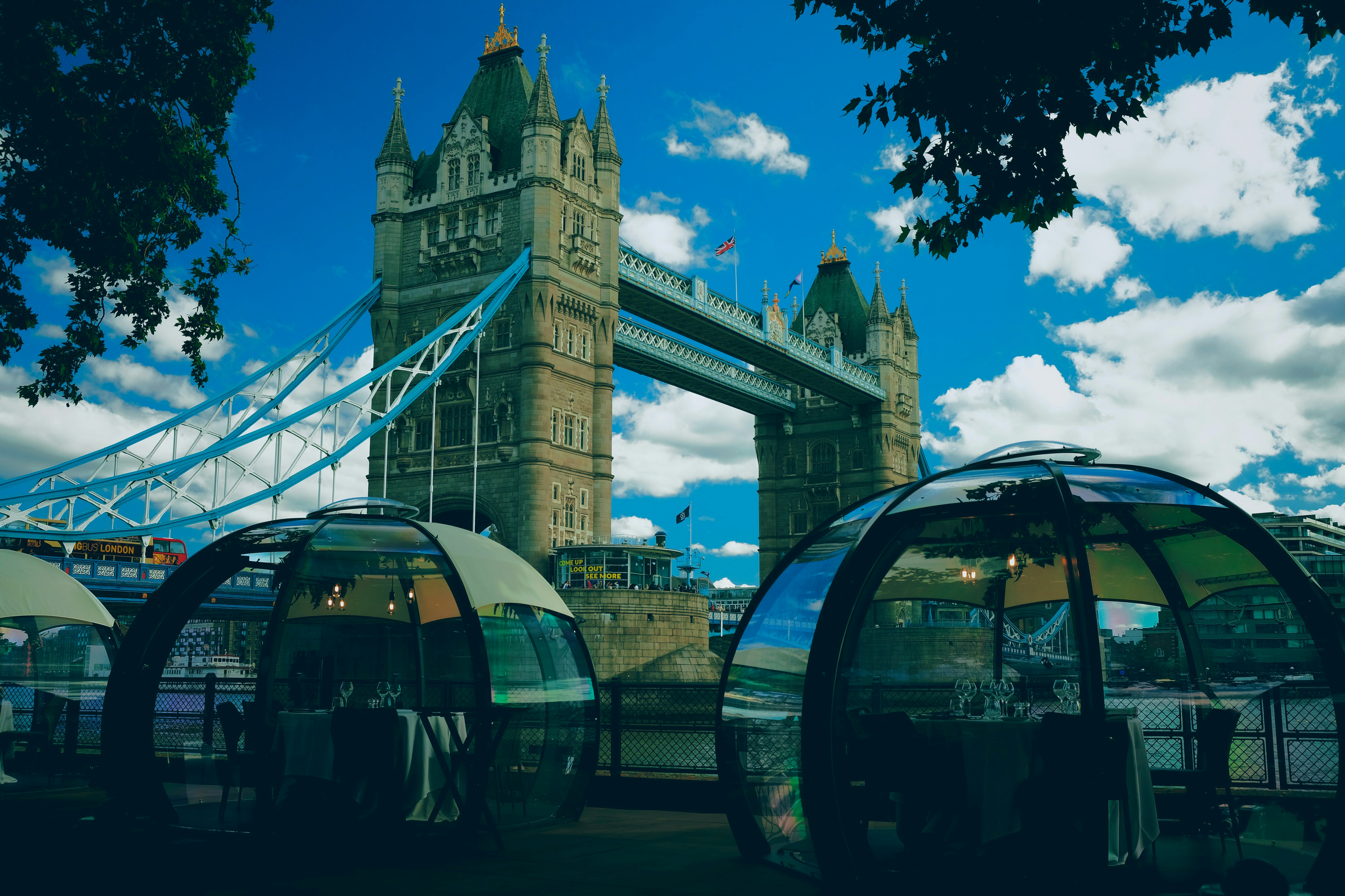 Transparent dining pods set against the iconic Tower Bridge, showcasing a blend of modern hospitality and historic architecture.