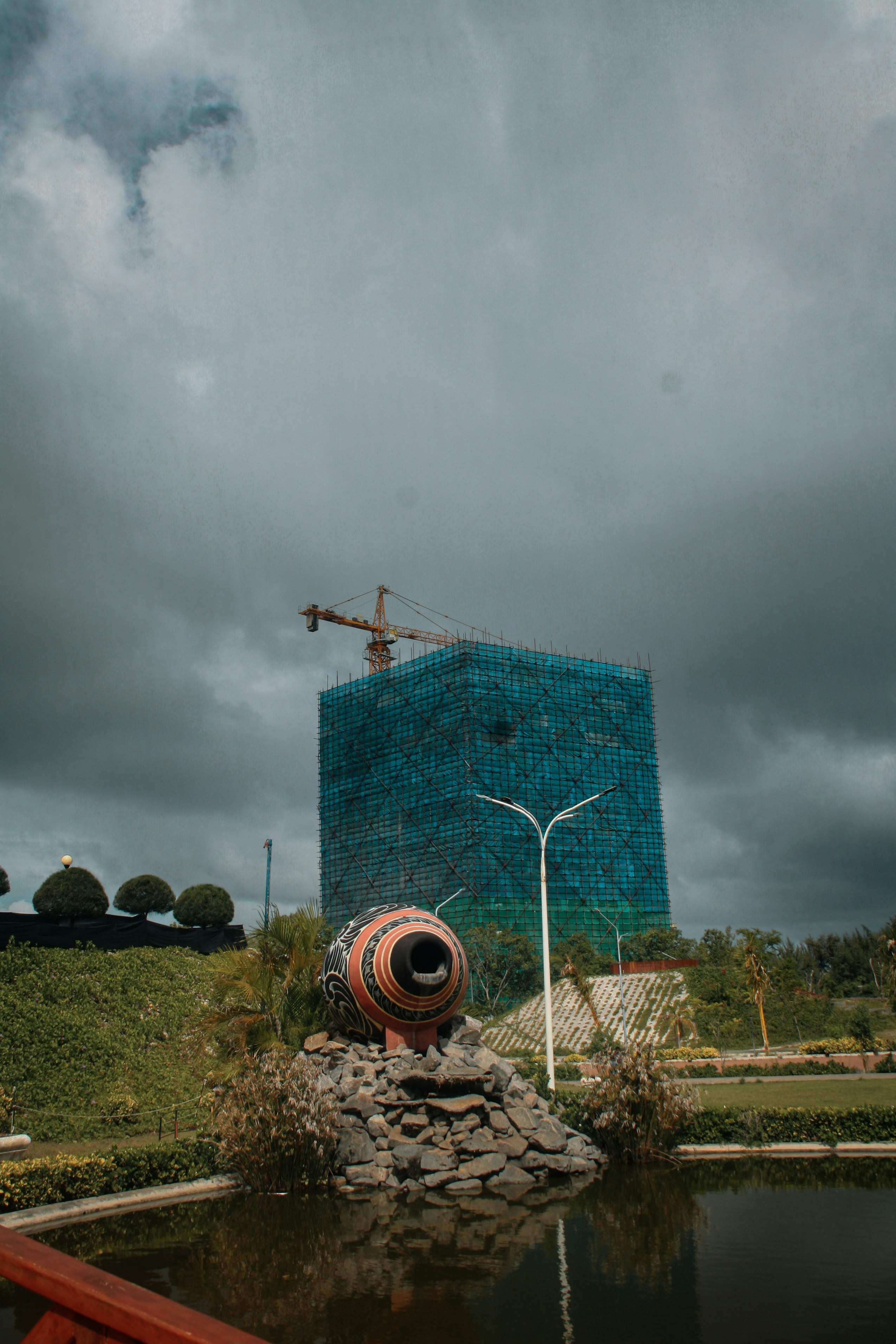 Blue Scaffold Monolith Rising Over a Storm-tinged Park