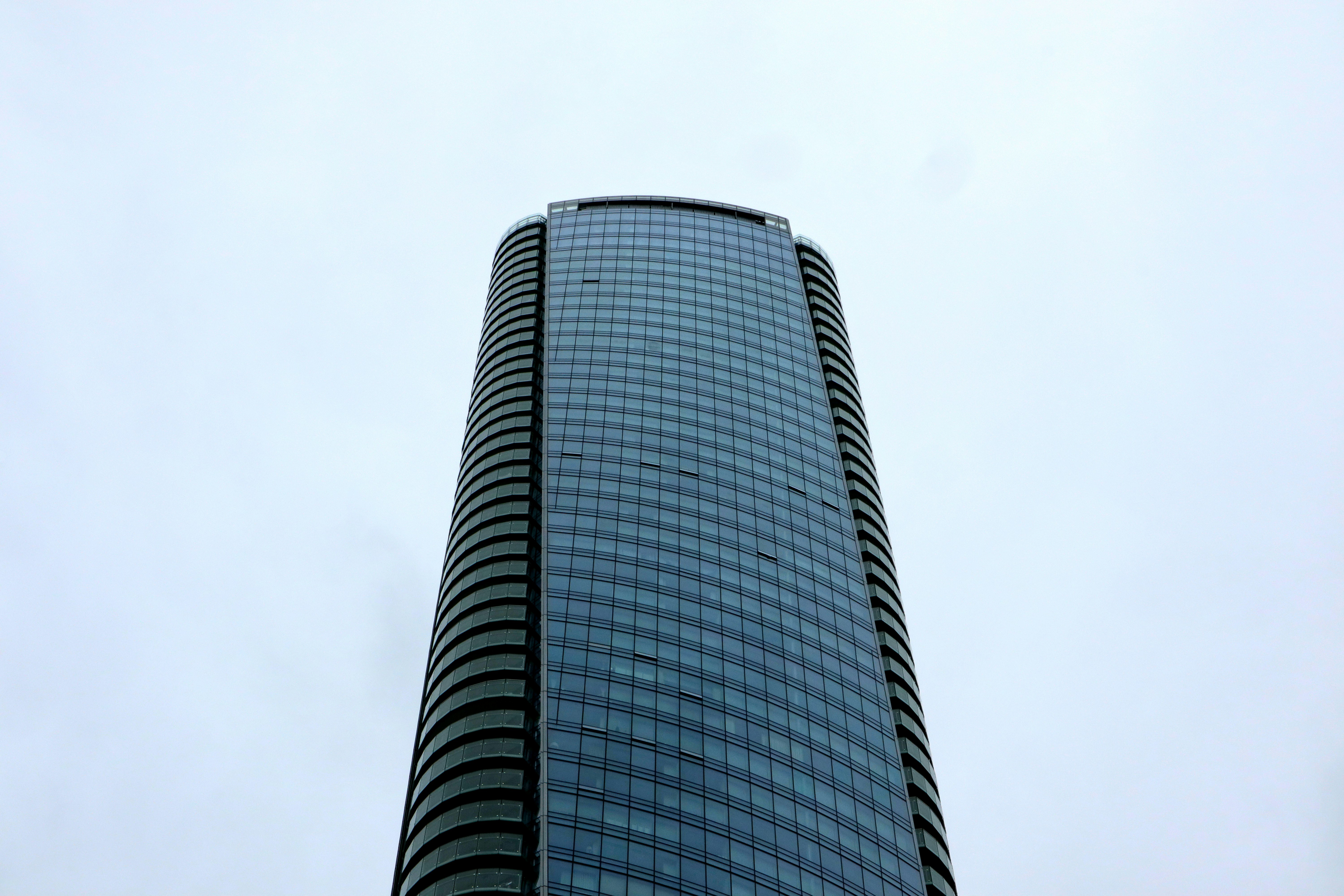 Curved Glass Monolith Reaching Toward the Clouds