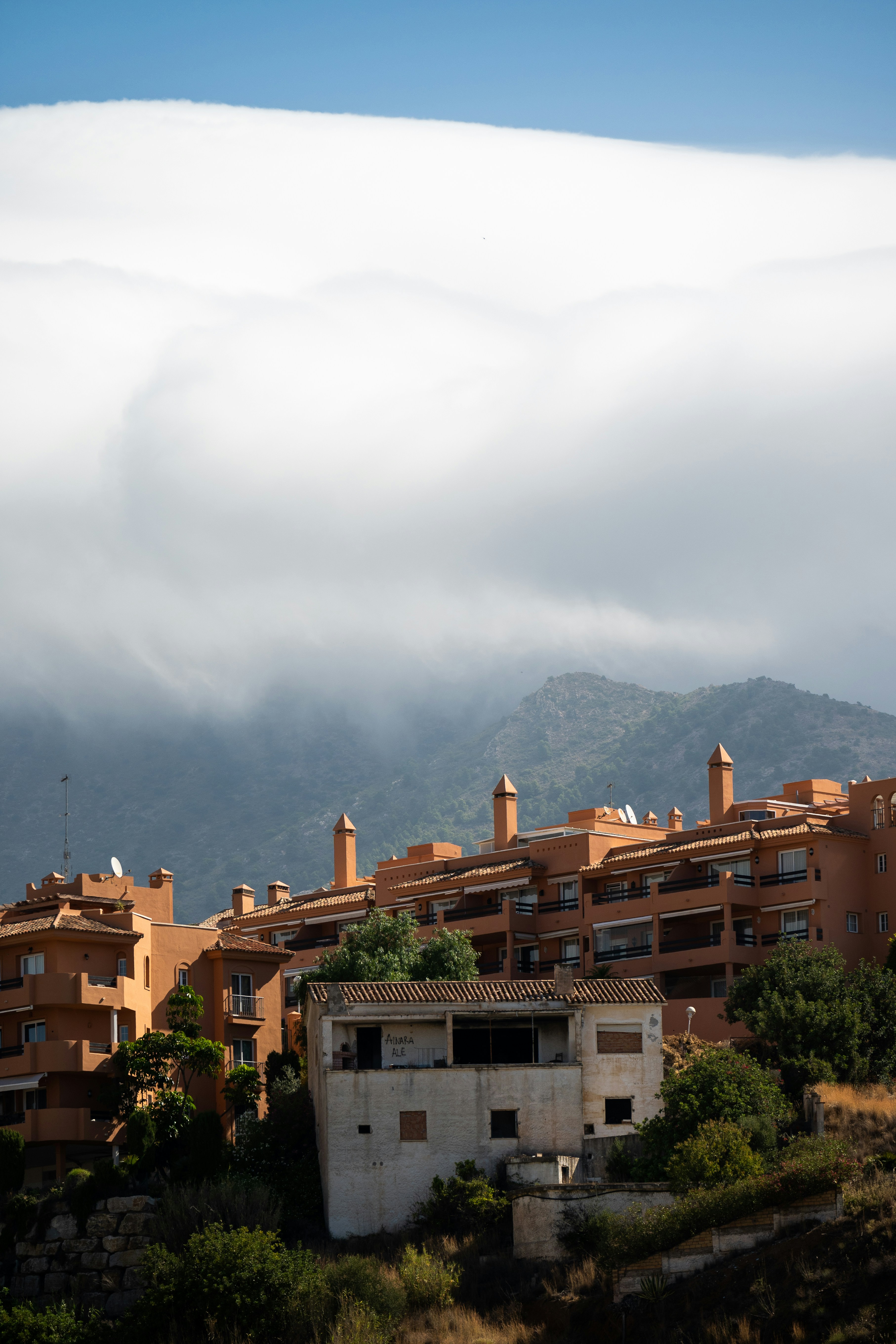 Terracotta Utopia: Houses Nestle Between Slope and Sky