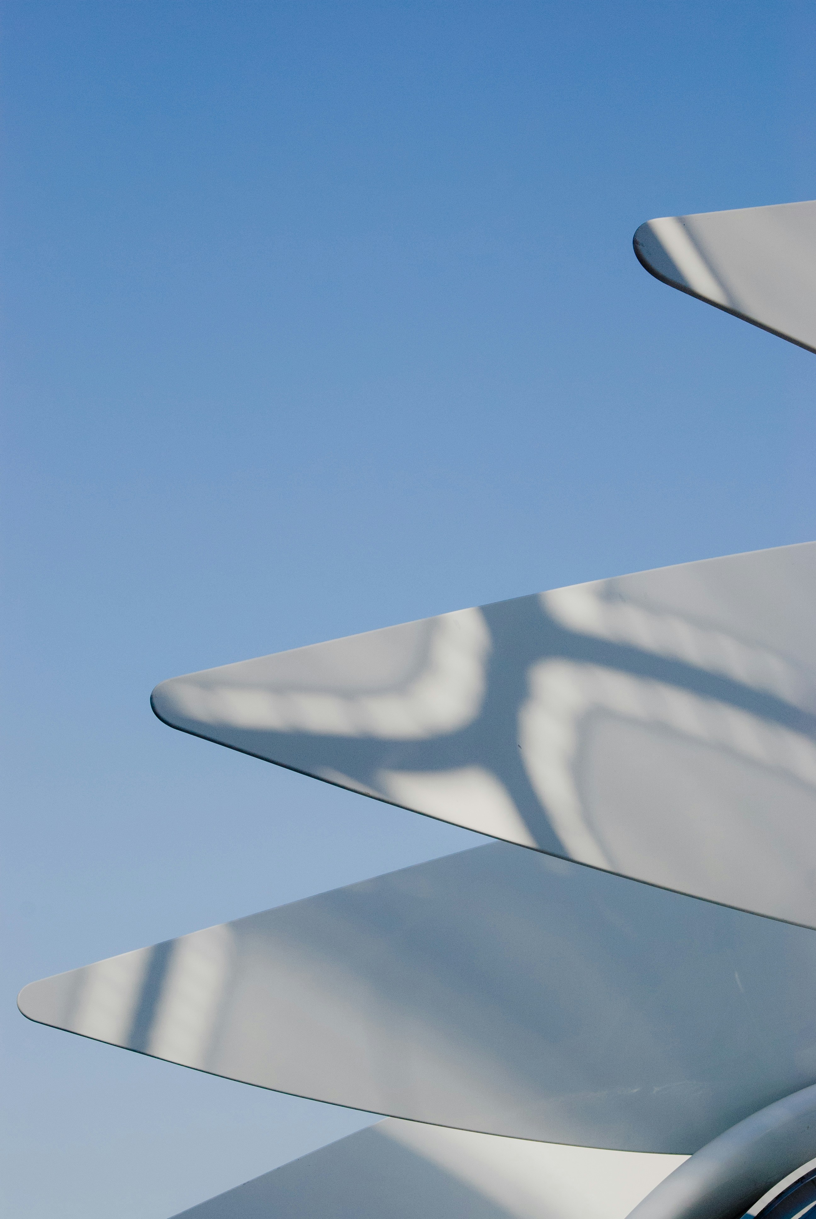 Angles in the Sky: Close-Up on Winglet Edges Against a Pristine Blue Backdrop