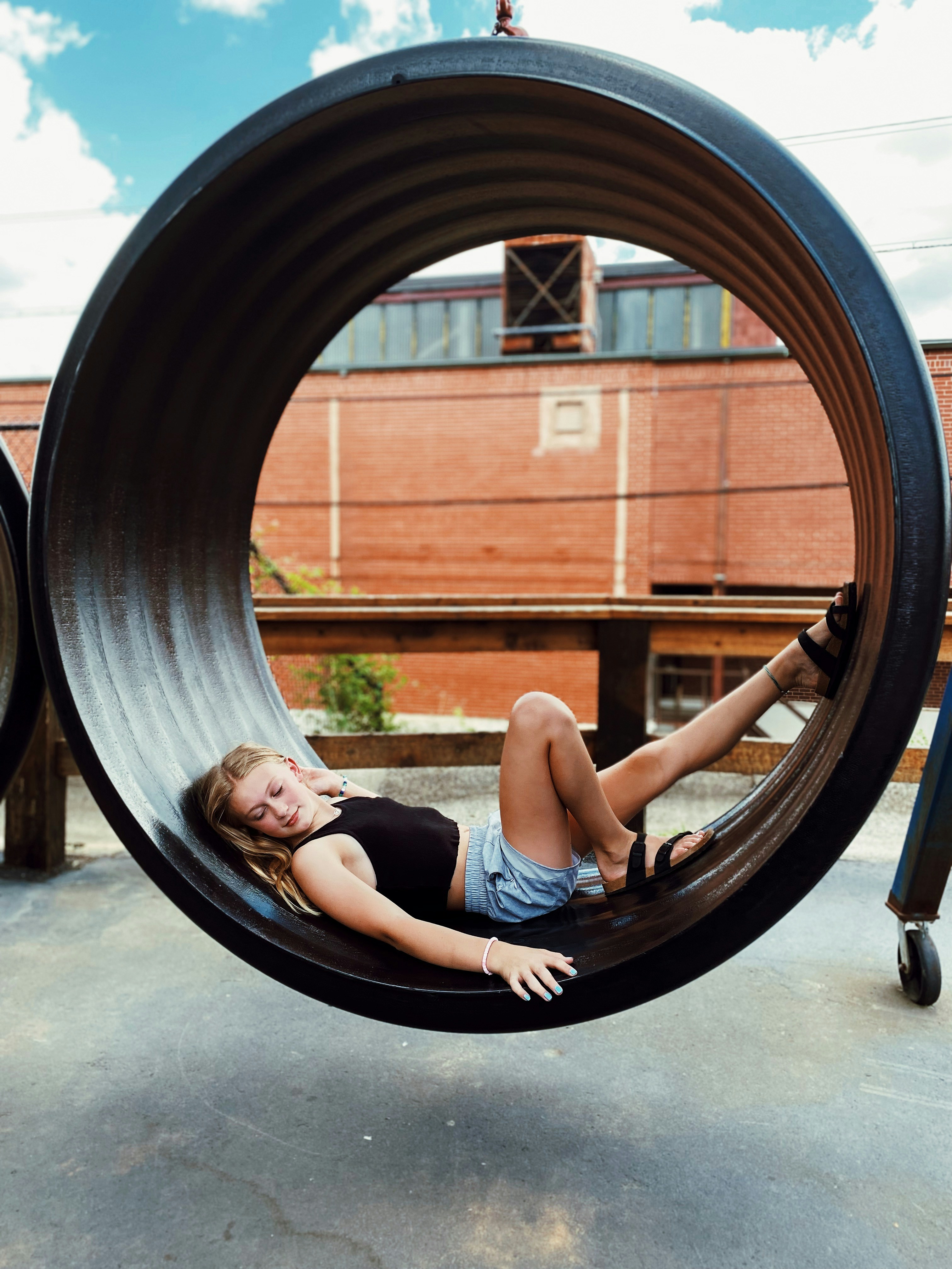 Reclining in the Ring: A Sunlit Portrait Inside a Massive Playground Tire