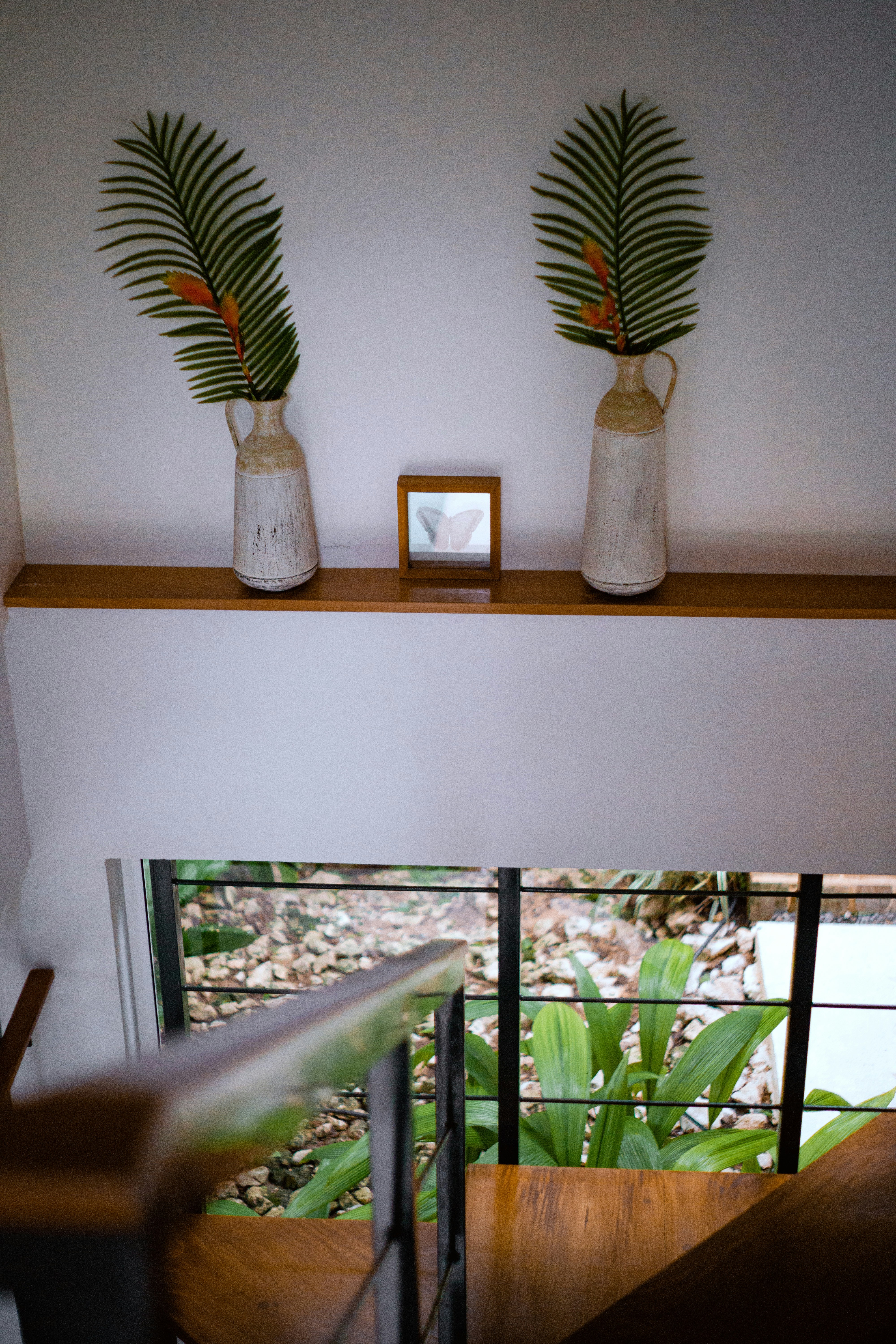 a couple of vases with flowers on a shelf