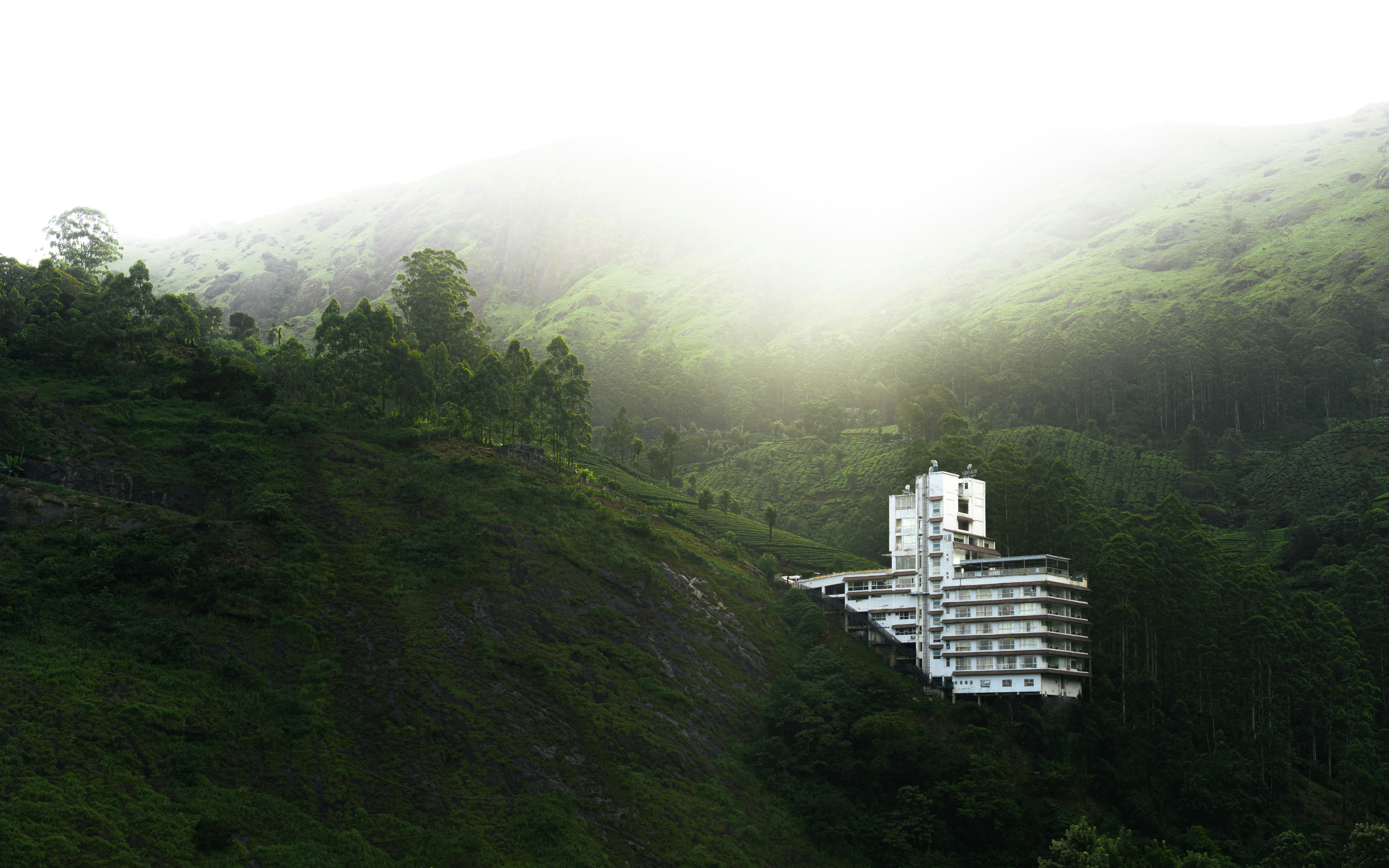 Mist-Kissed Cliffside Lodge Crowned by Green Slopes