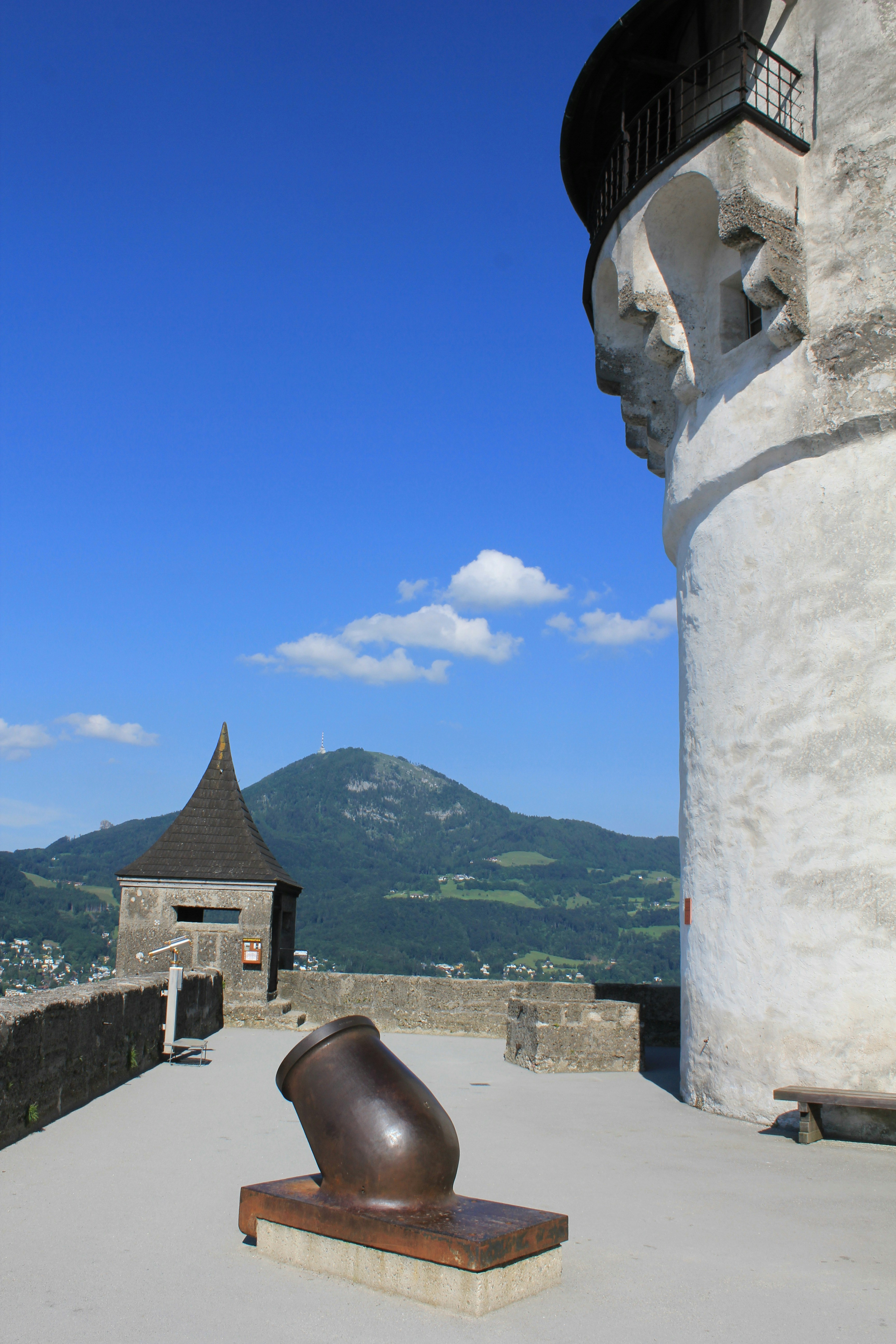 Bronze Cannon on a Sunlit Fortress Terrace Framing Alpine Backdrop