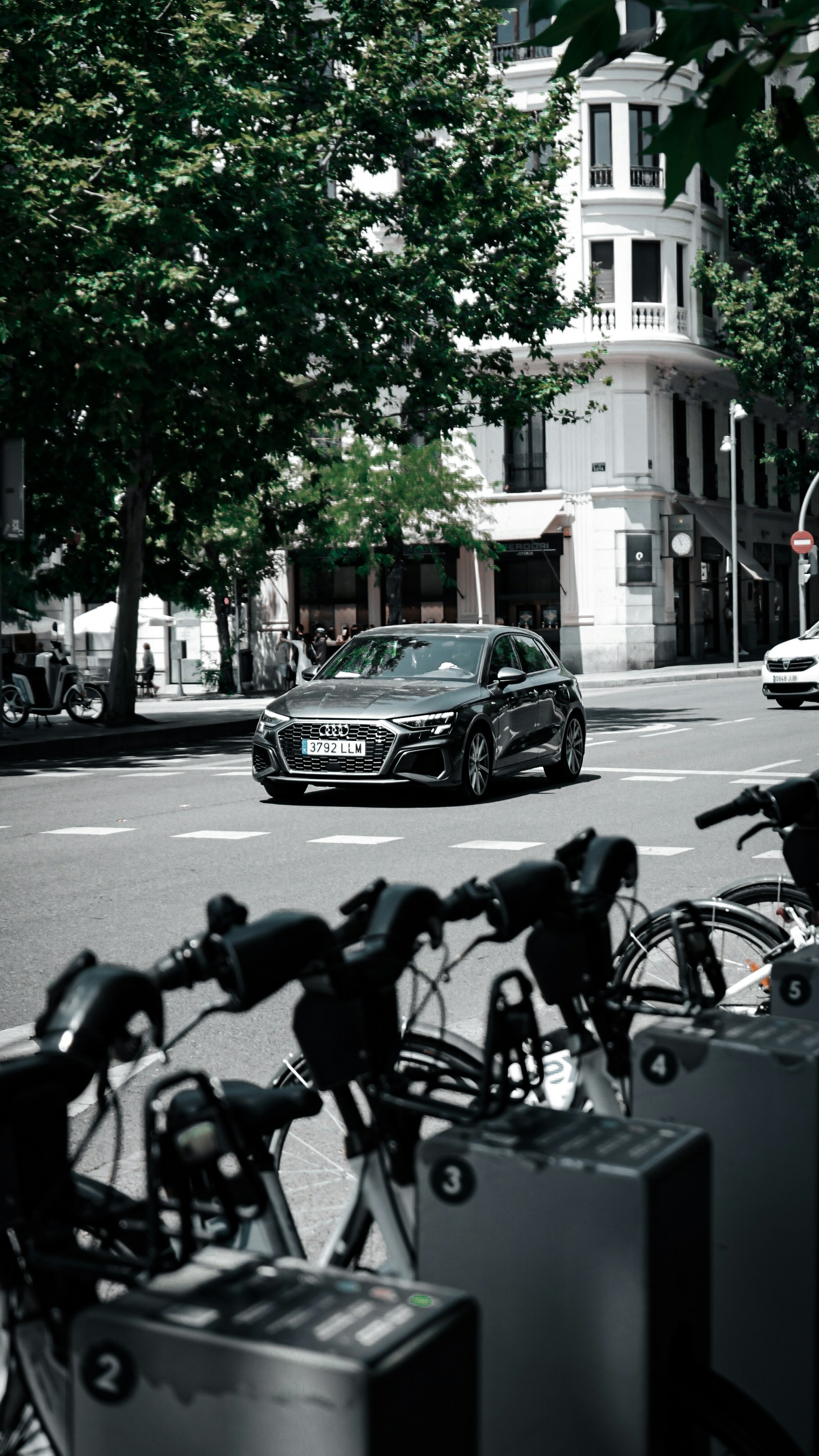 Urban Pulse: The Audi Between Bicycles and Leaf-Shaded Facades