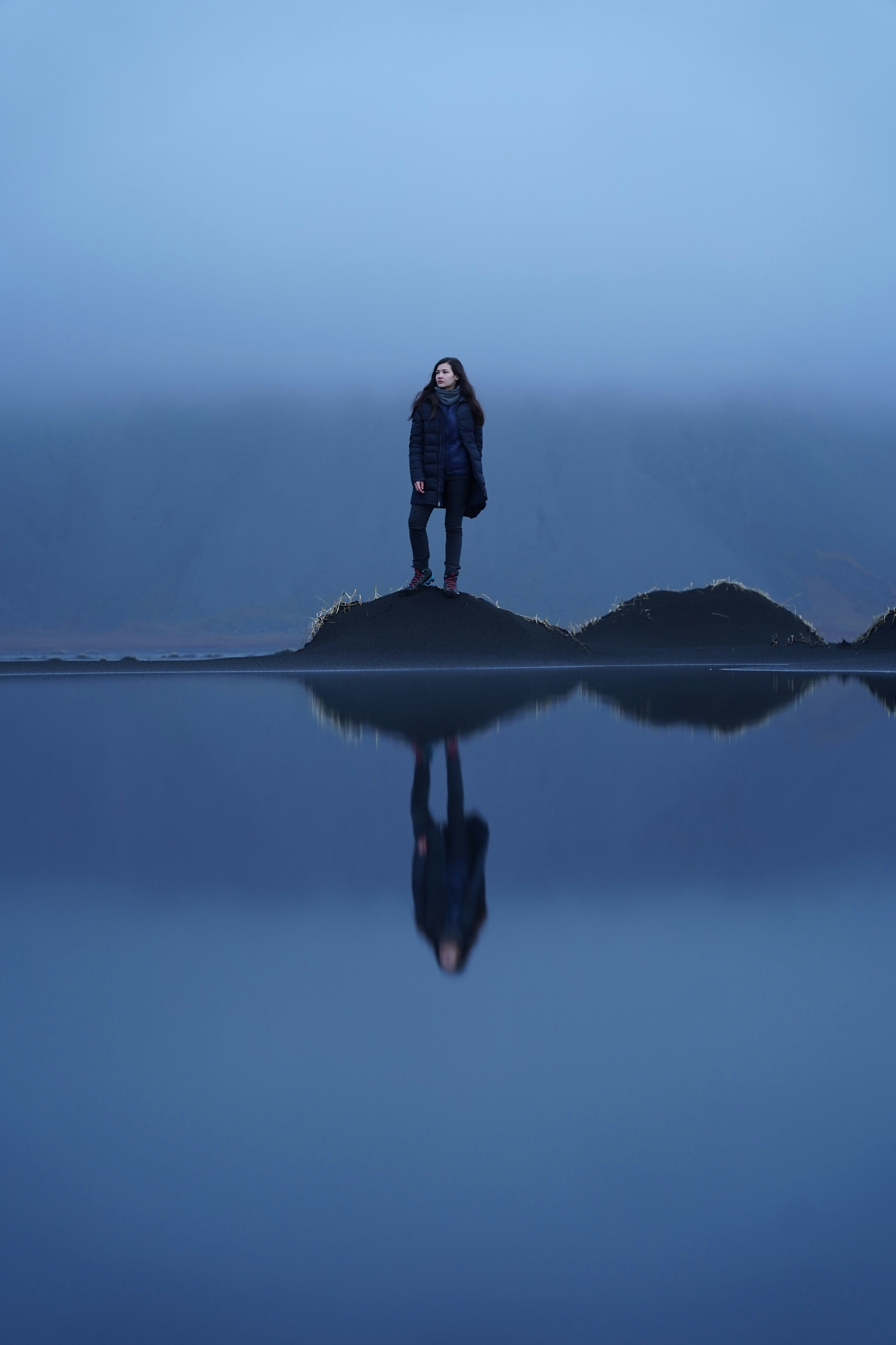  lone figure on a promontory against a blue horizon