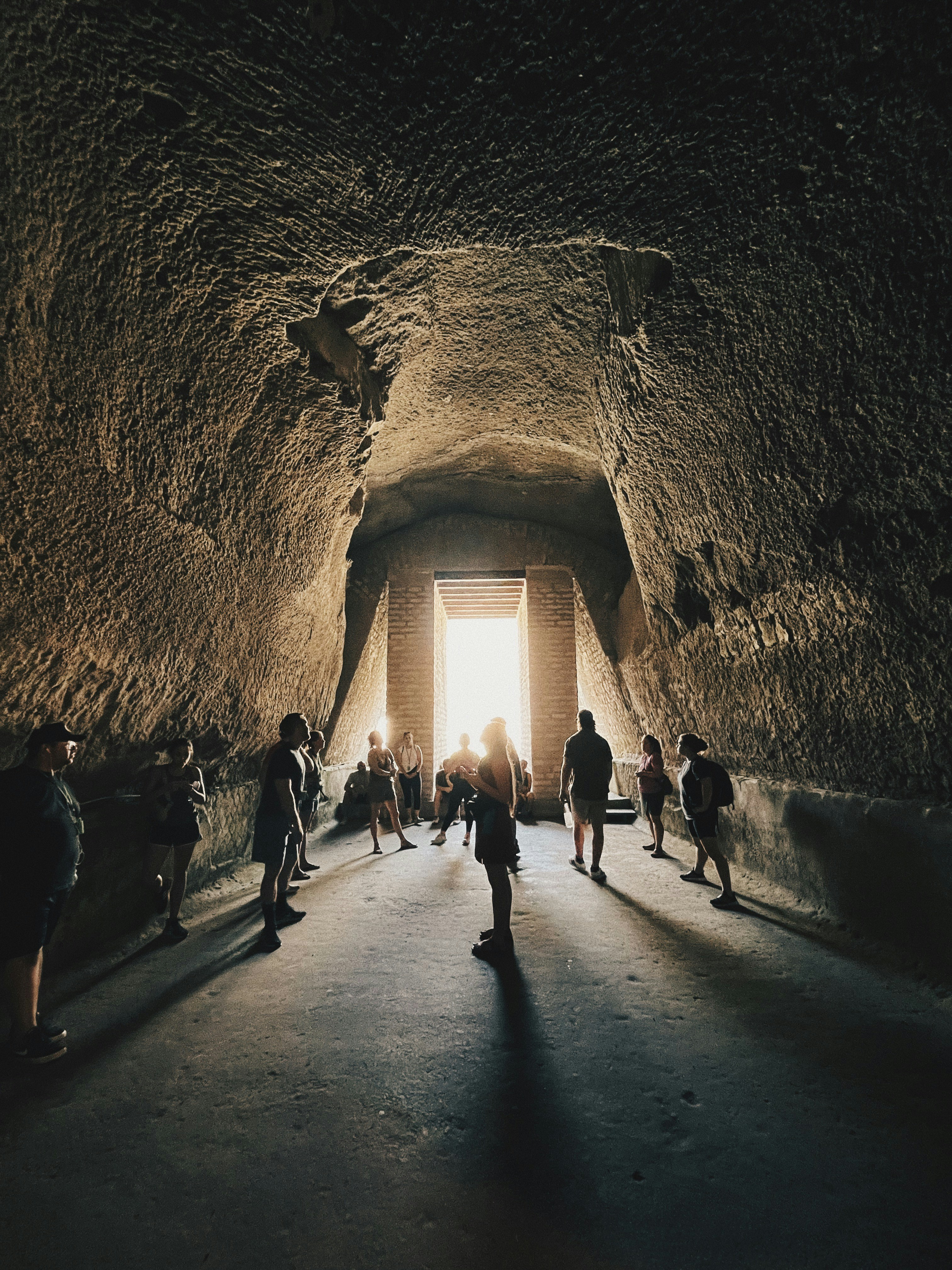 Gateway to Daylight: Silhouettes in a Cavern Corridor
