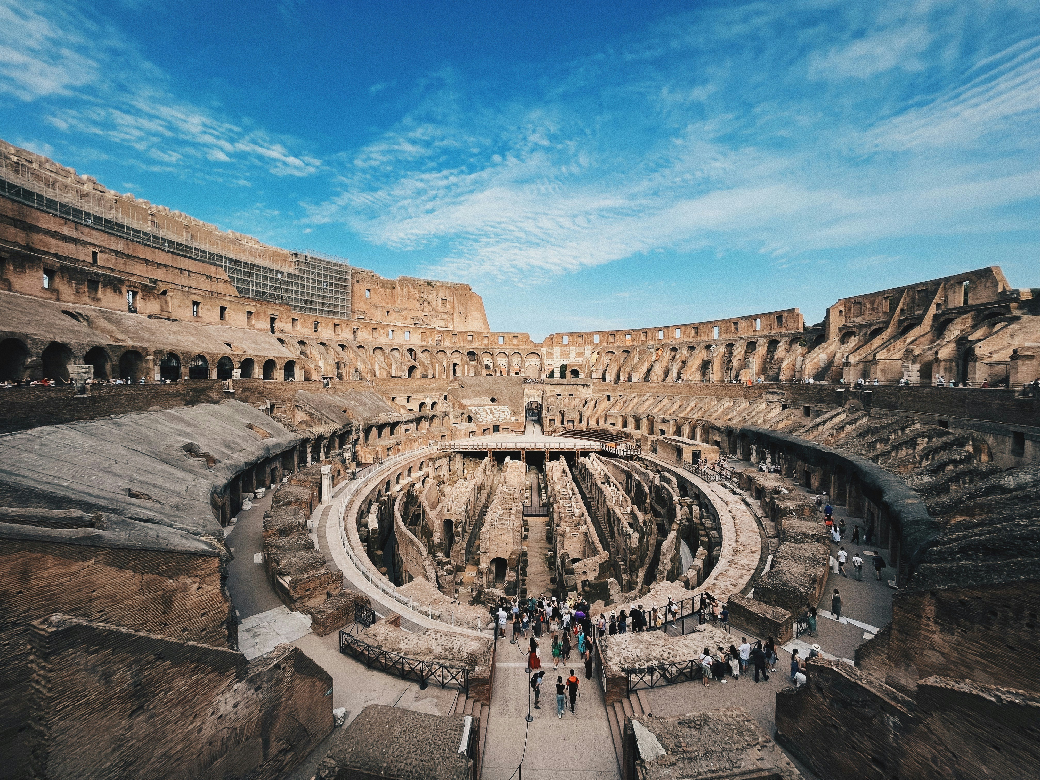 Sunlit Circles: Tourists Tracing the Colosseum's Ancient Ring
