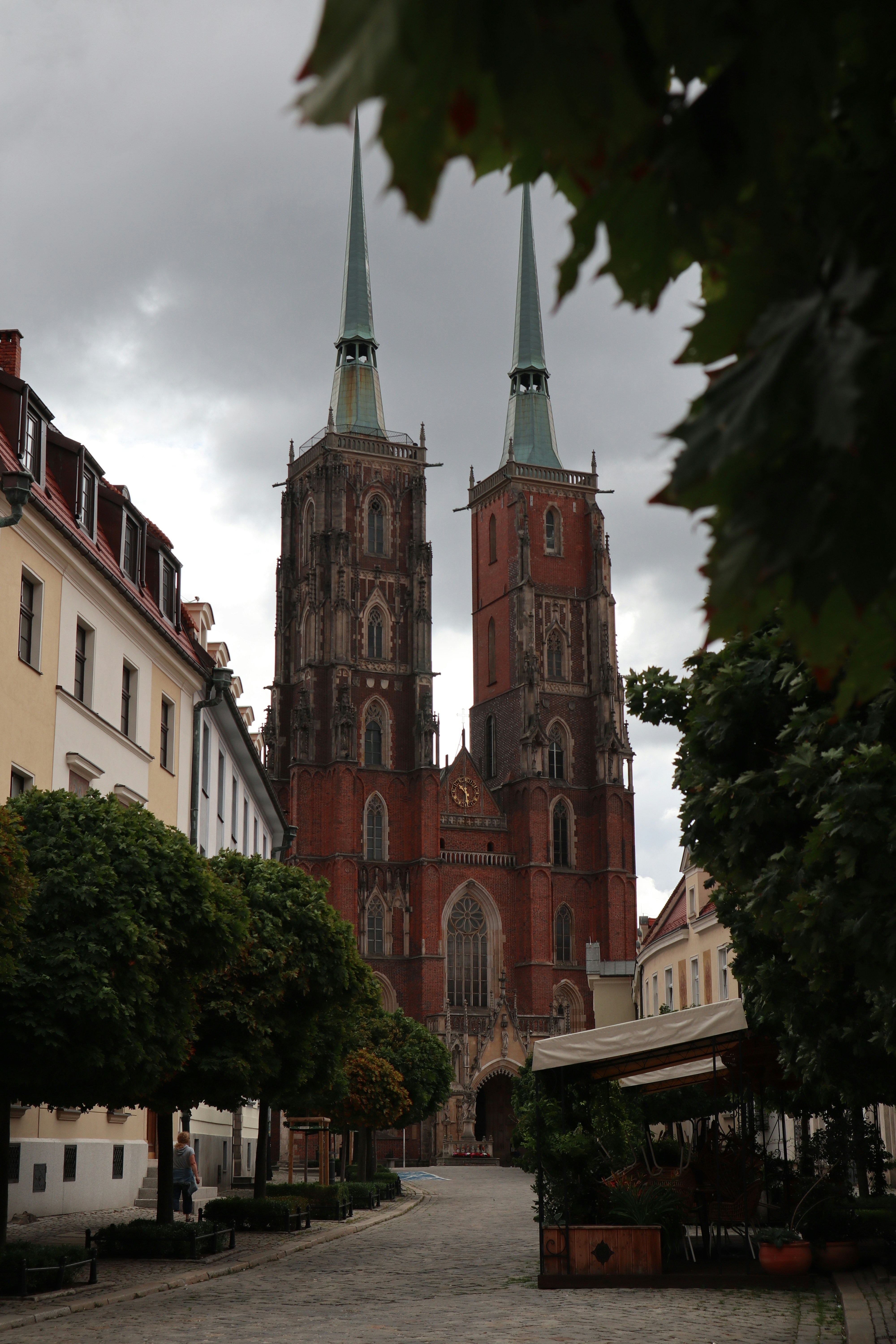 Twin Spires Framing a Cobblestone Street: A Gothic Cathedral in Red Brick