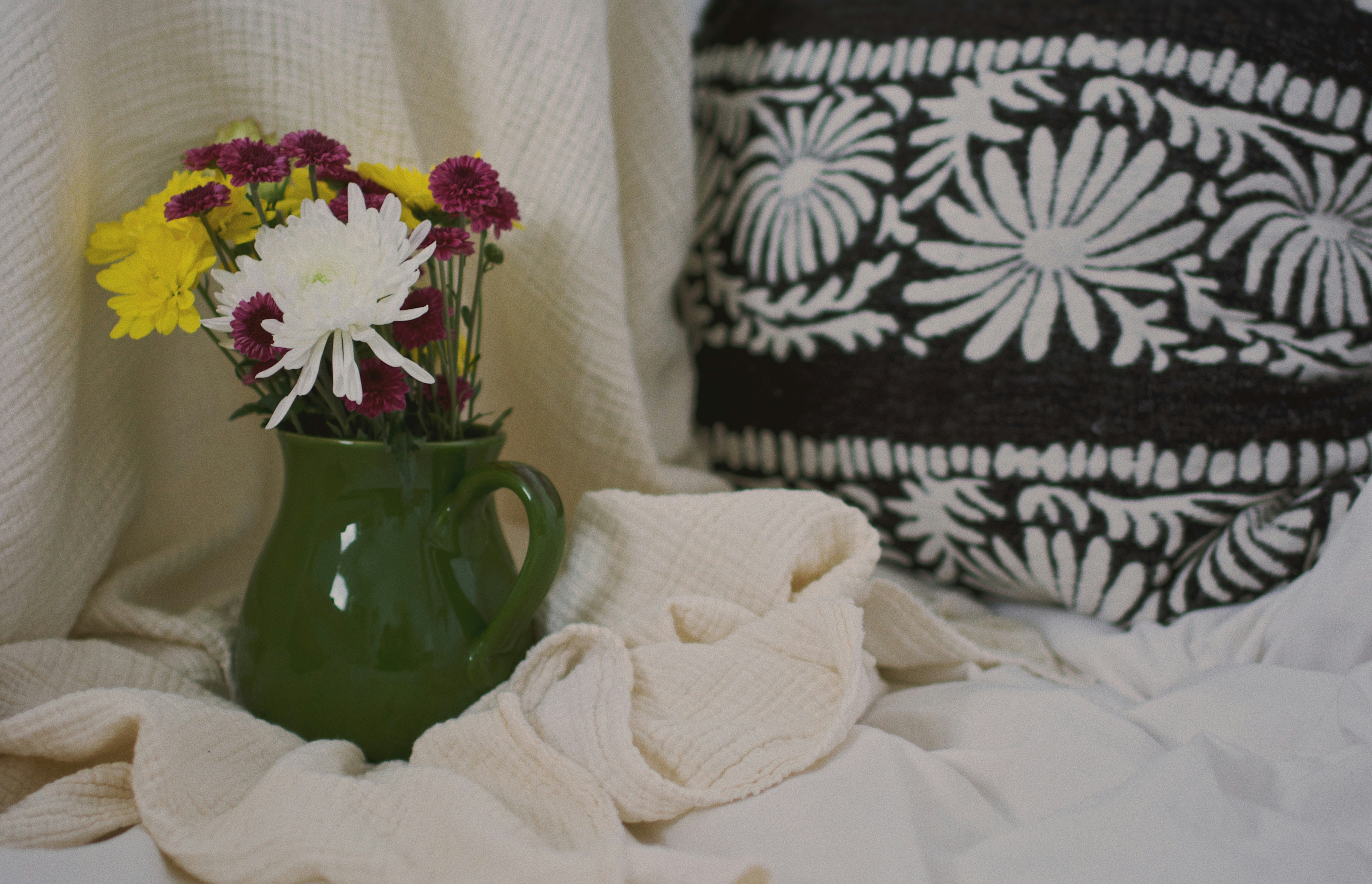 Emerald Vase of Wildflowers Nestled Between Cream Knit and Black-and-White Florals