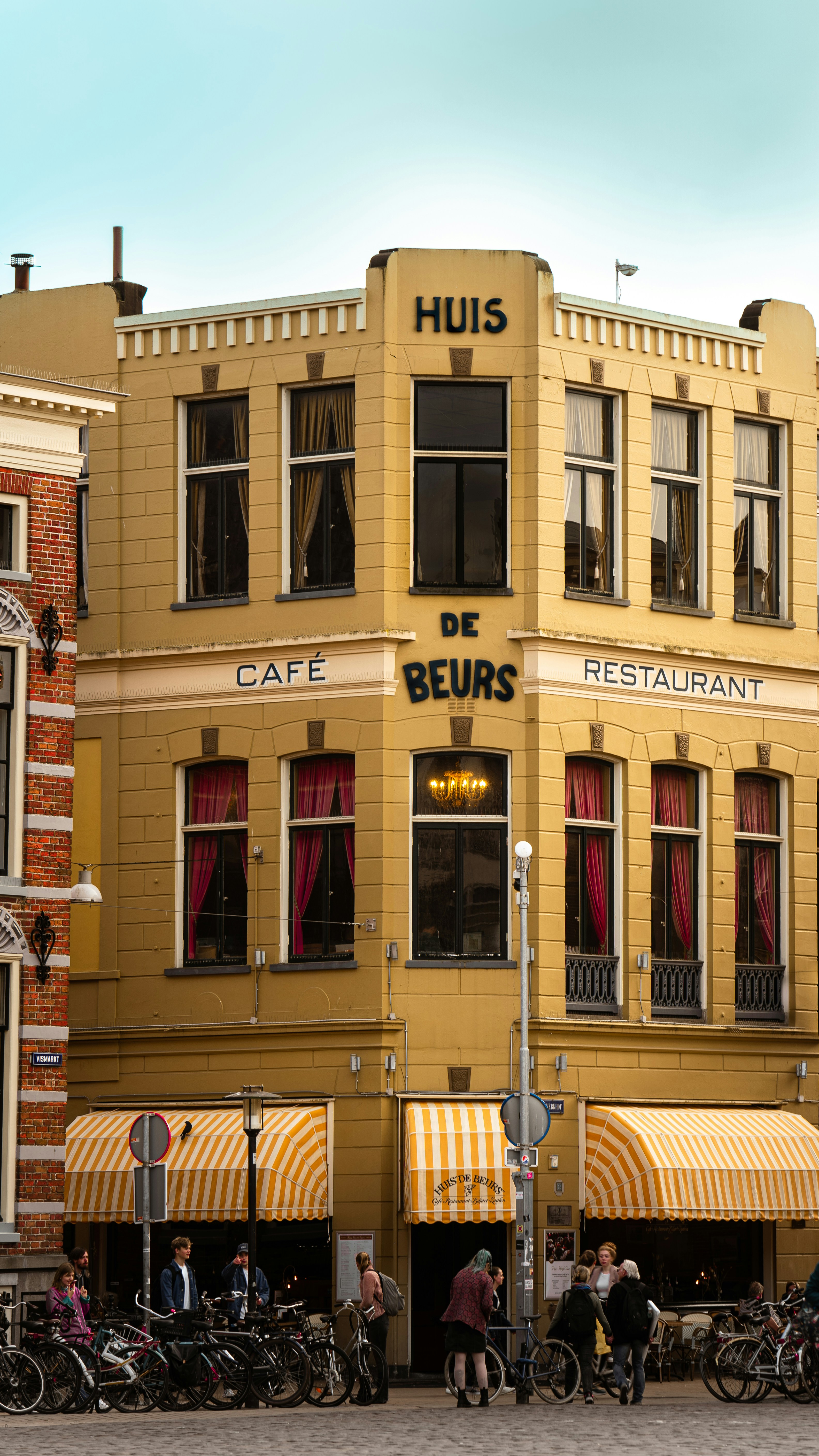 Beurs House: Sunlit Yellow Facade Framed by Bicycles