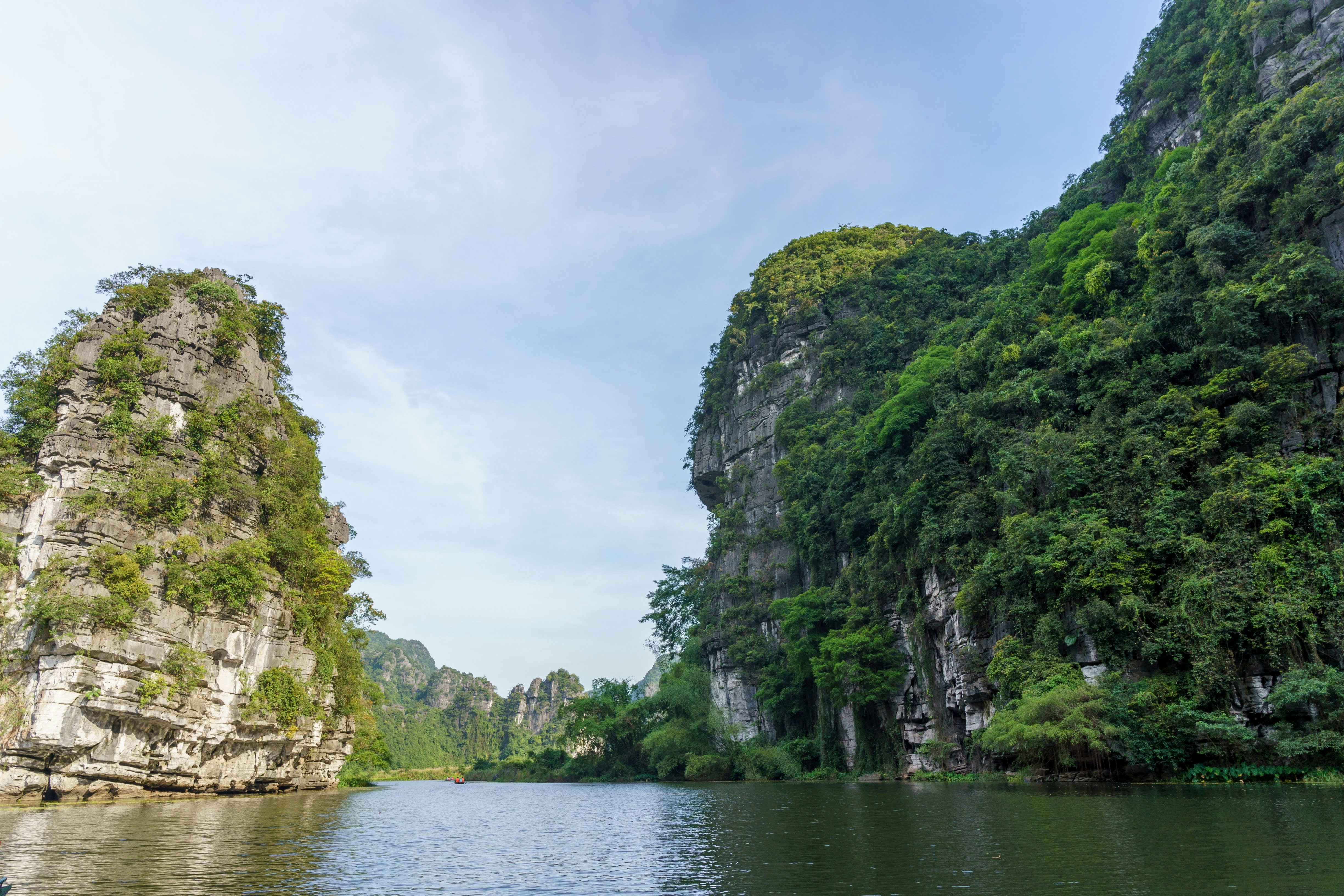 A body of water with a cliff and trees on the side photo – Free Ninh ...