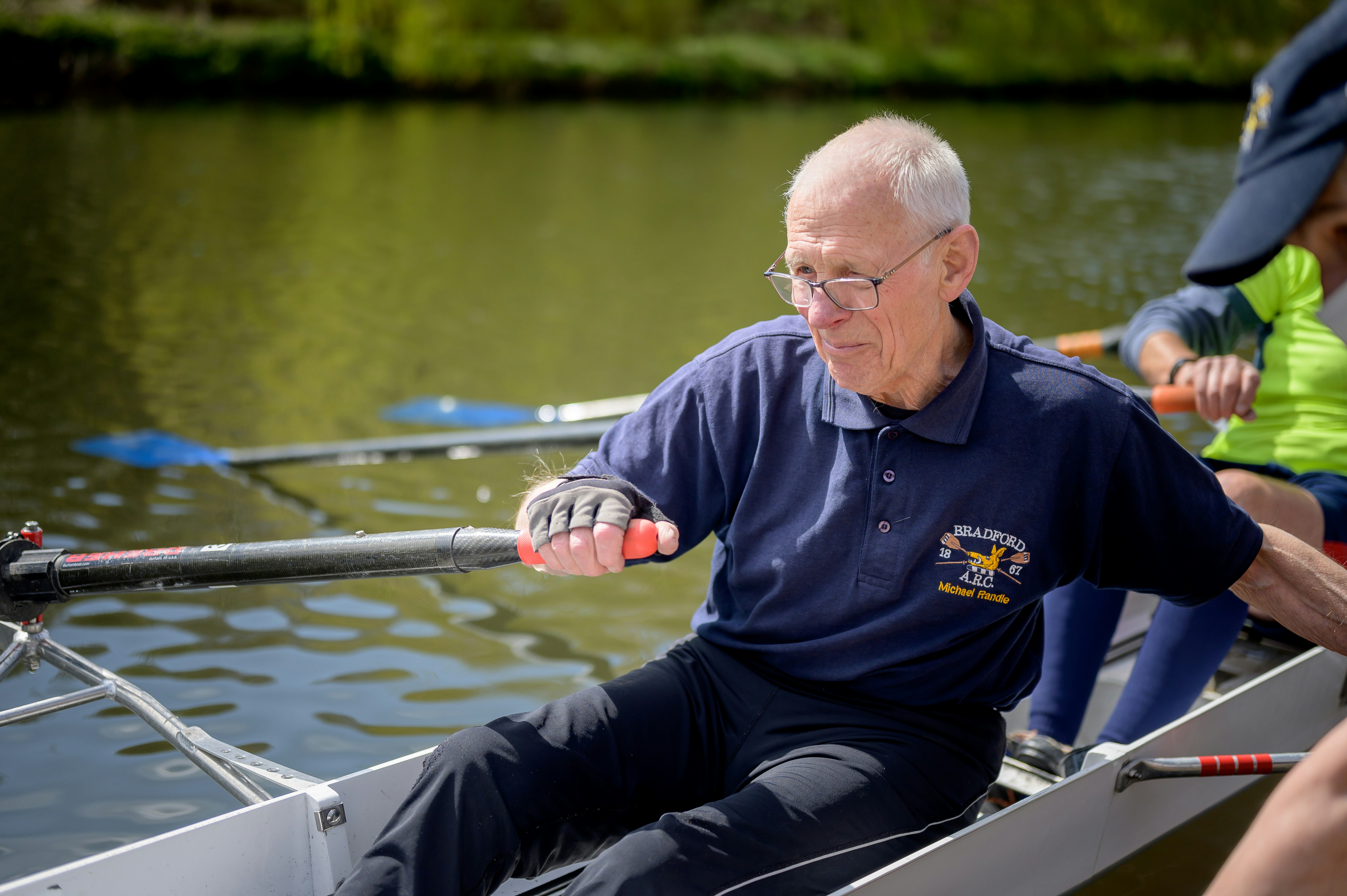 The Quiet Oarsman: Focused Stroke on a Sunlit Riverside