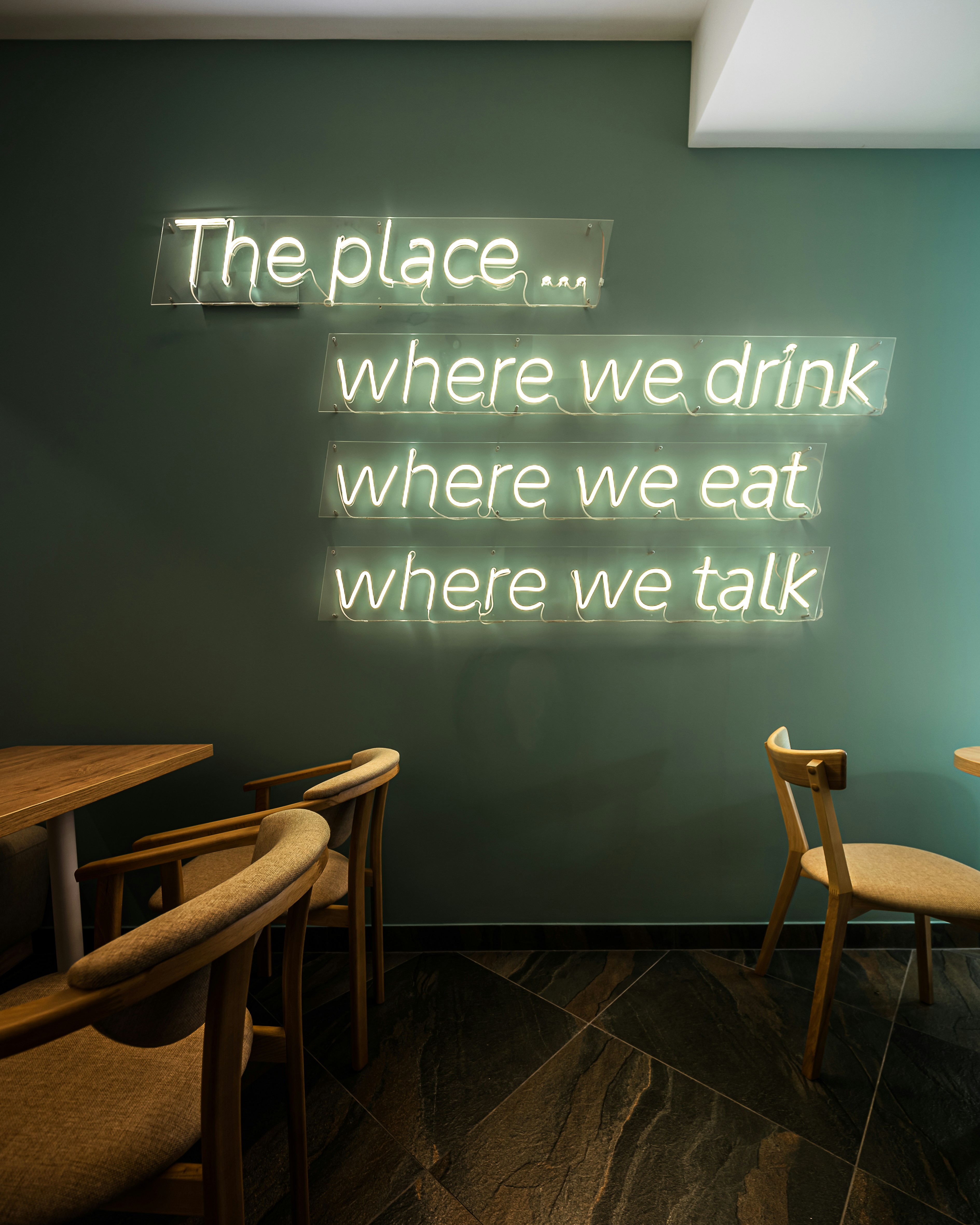 Neon Script on a Teal Backdrop: A Quiet Café Corner