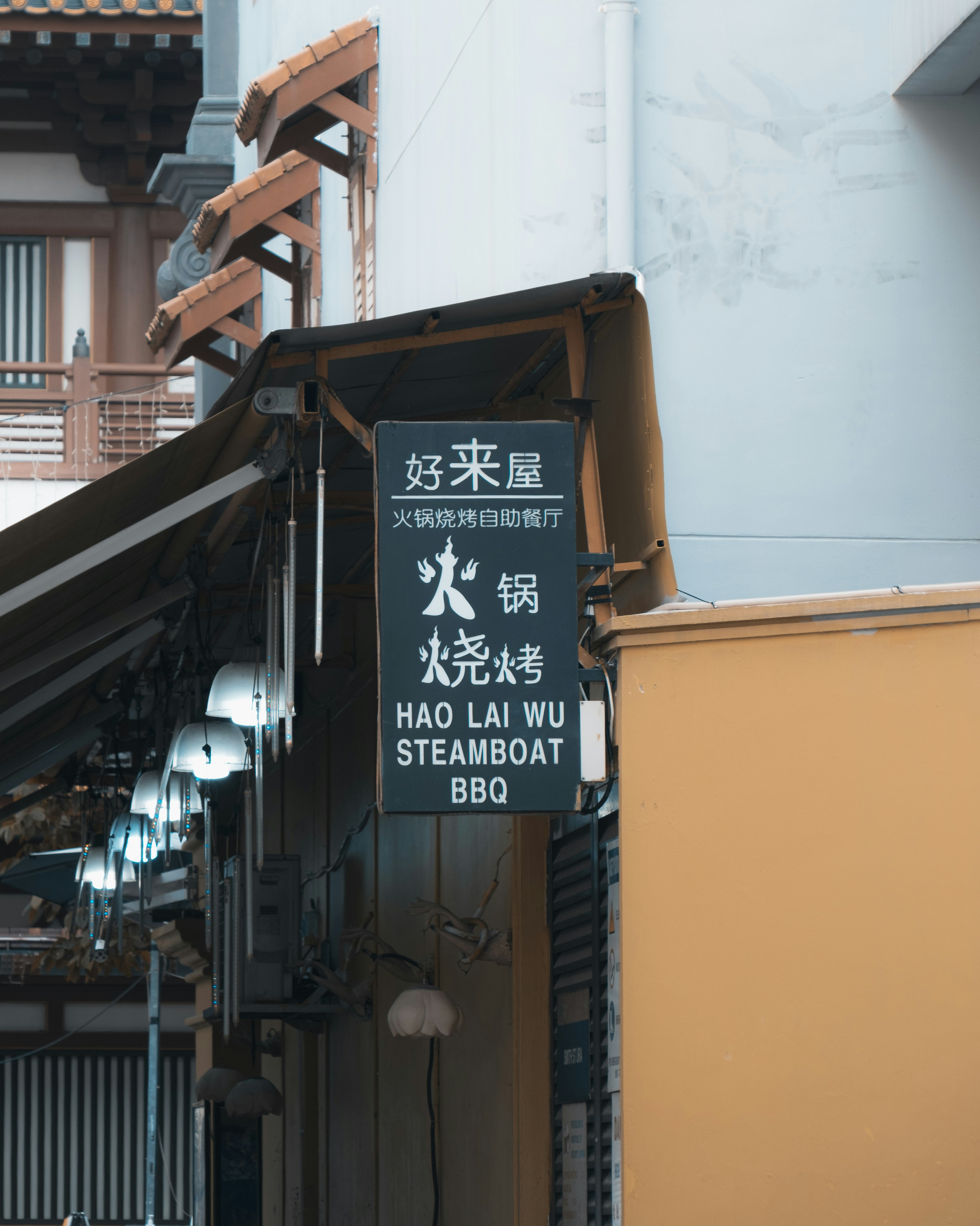 Lantern-Lit Hao Lai Wu BBQ Signboard Under a Shaded Arcade