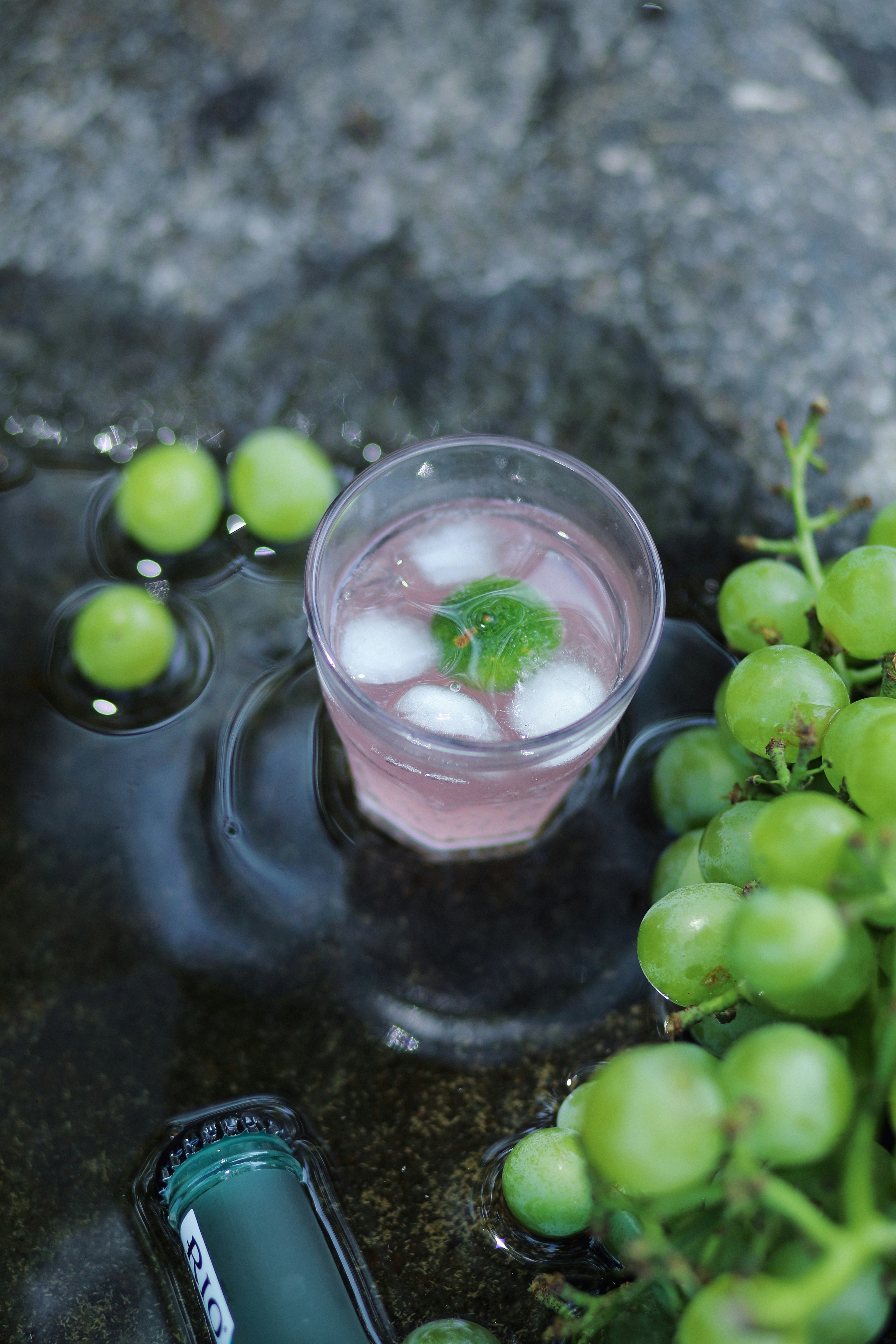 Rose-tinged sip: a crystal glass centerpiece among grapes and a bottle