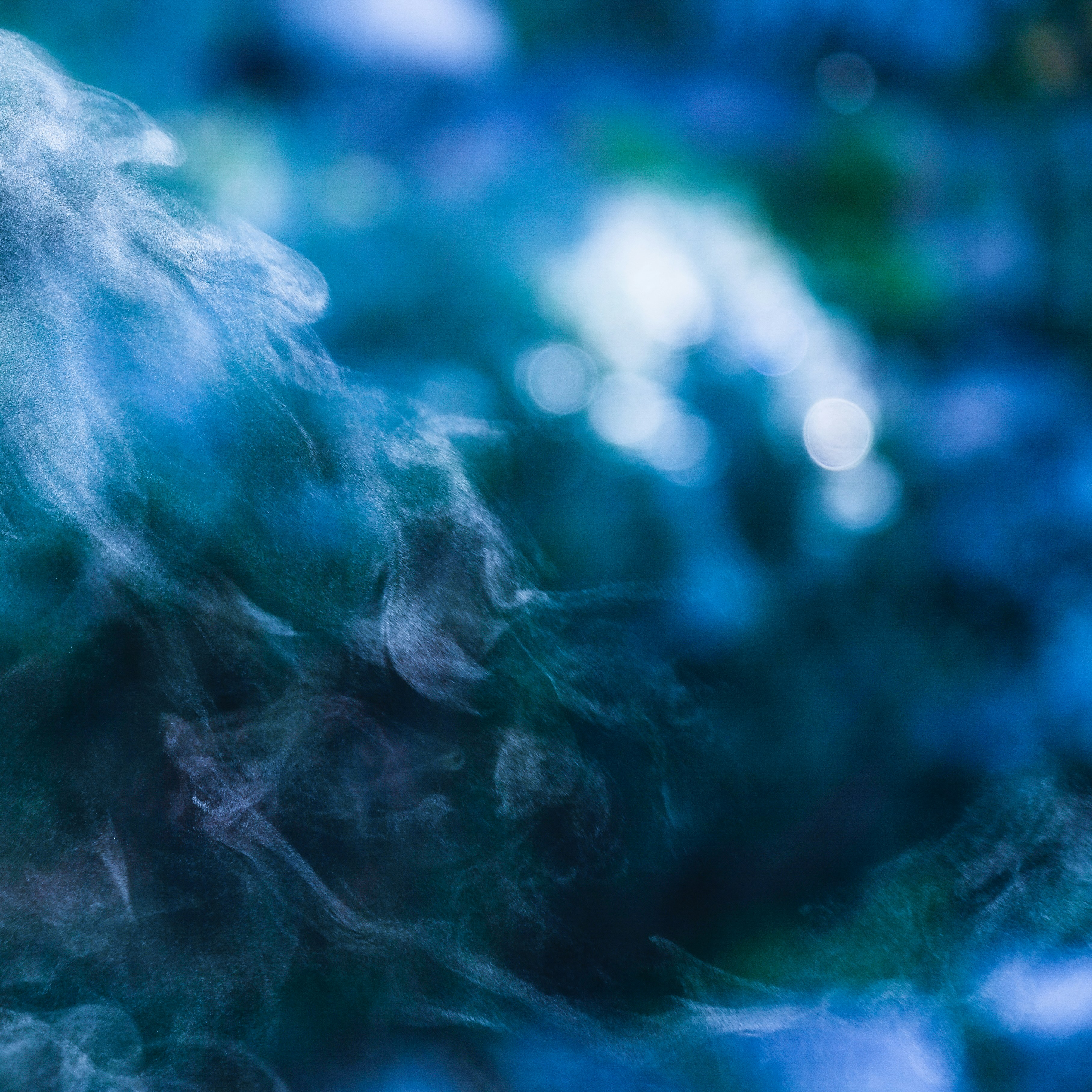 Swirling blue smoke against a softly blurred background.