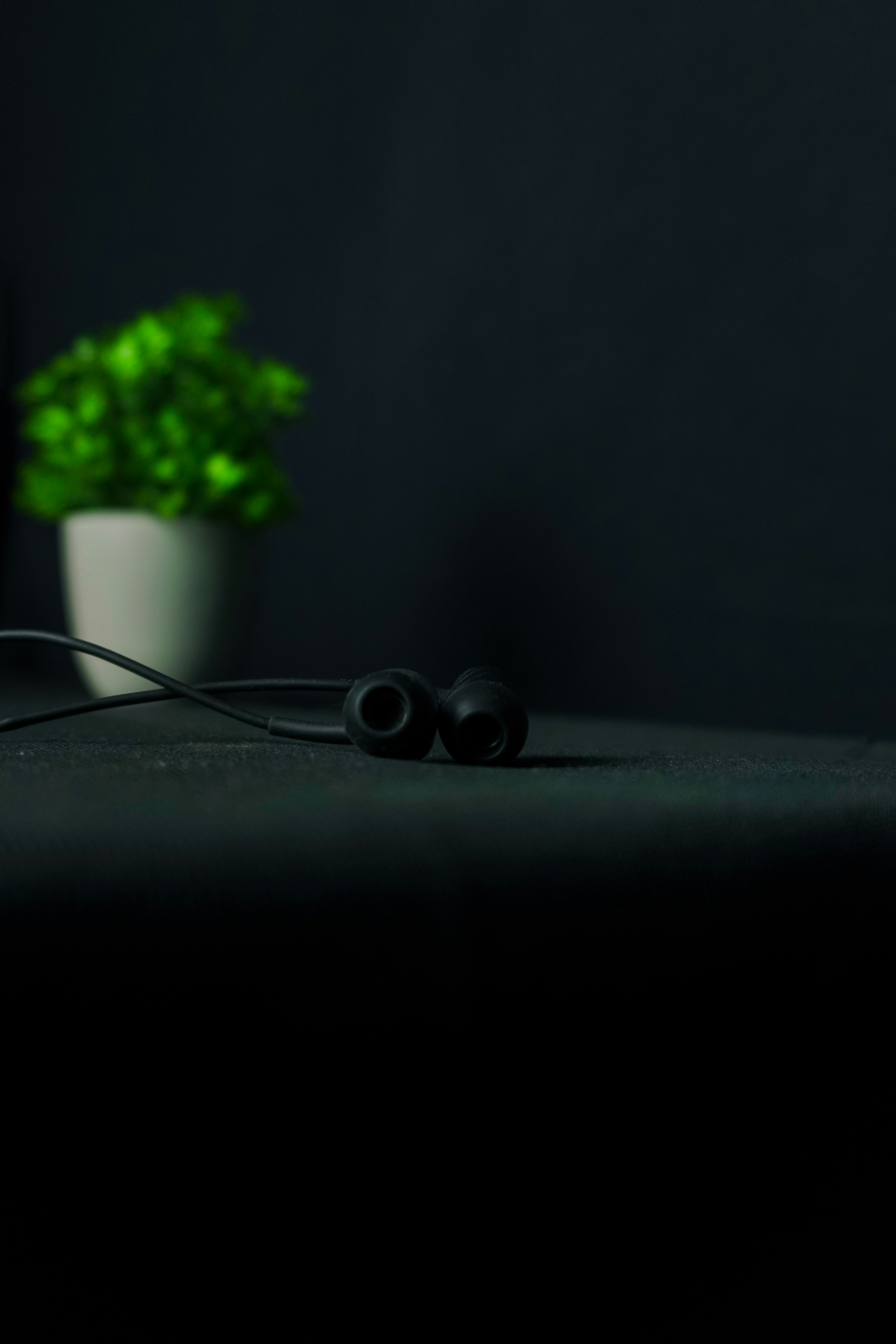 A black headphones on a table photo – Free Earphone photography Image ...