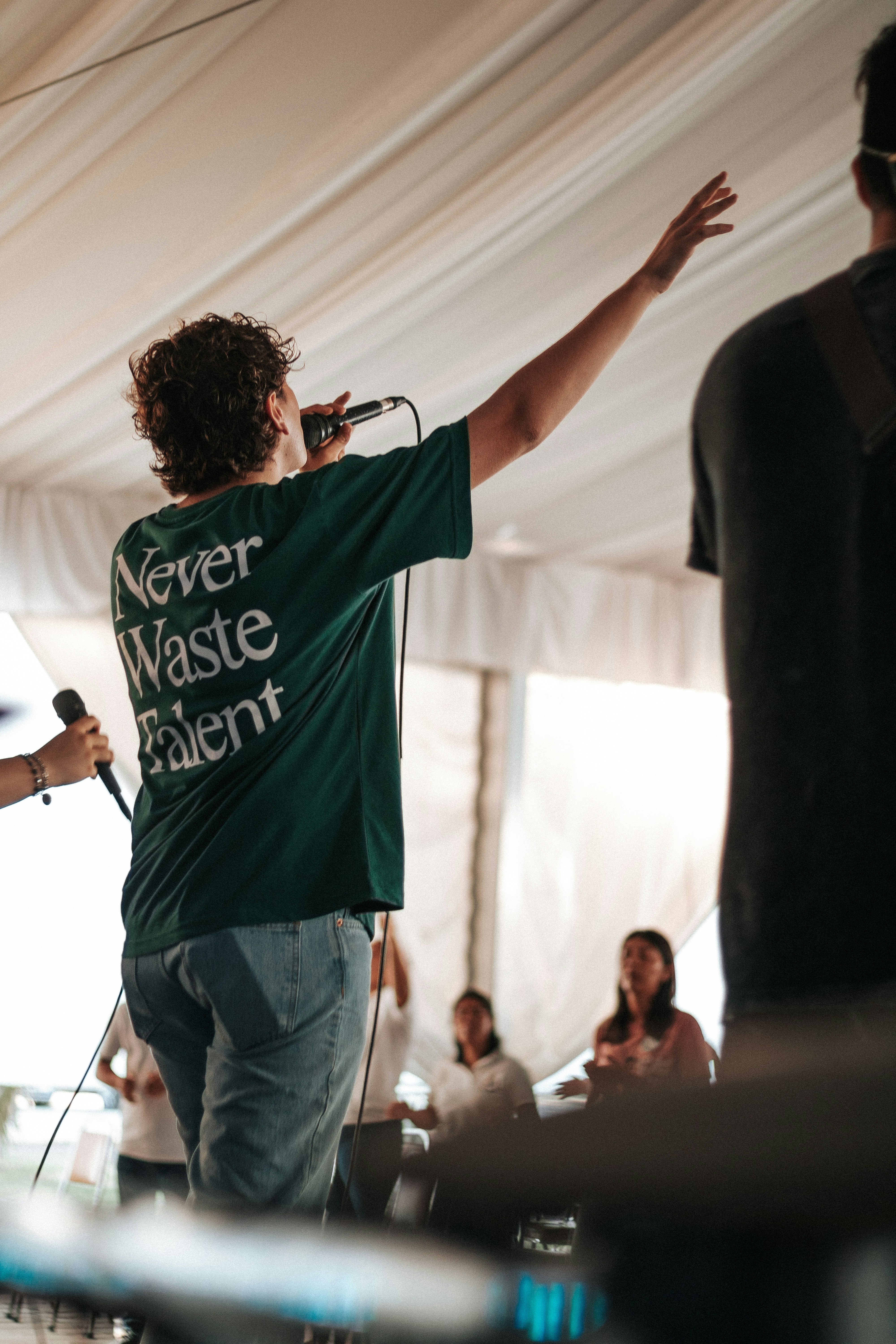 Mid‑Performance Moment: The Lead Singer's Reach in a Tent Stage